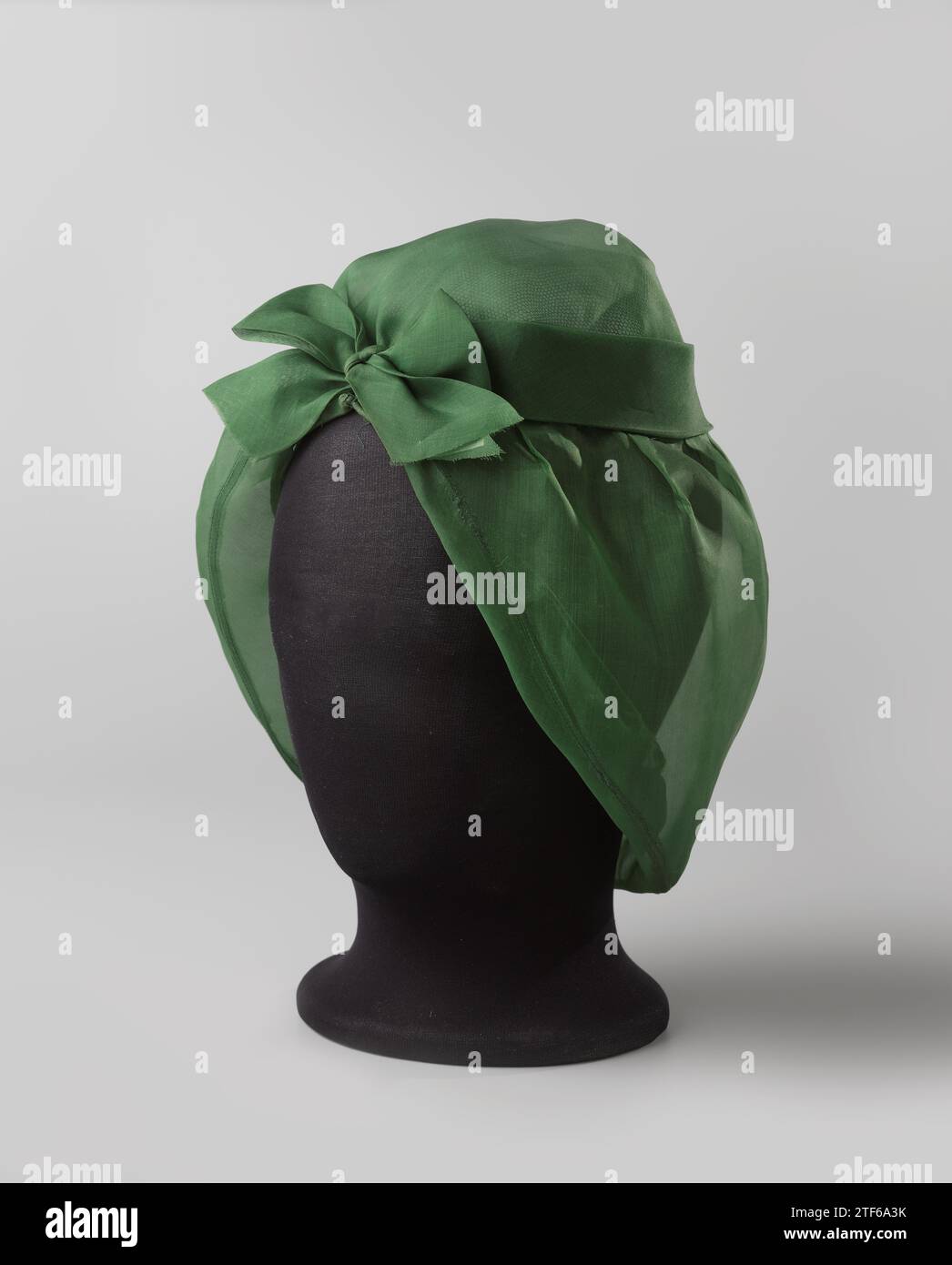 Hat of green organza with a small sphere at the rear of which a ribbon ...