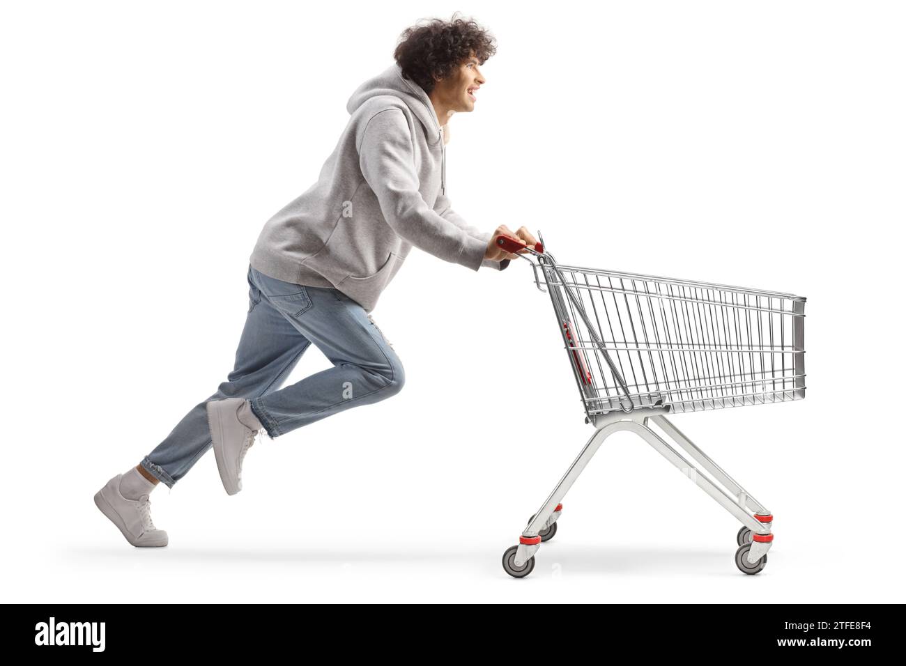 Young man running with a shopping cart isolated on white background ...