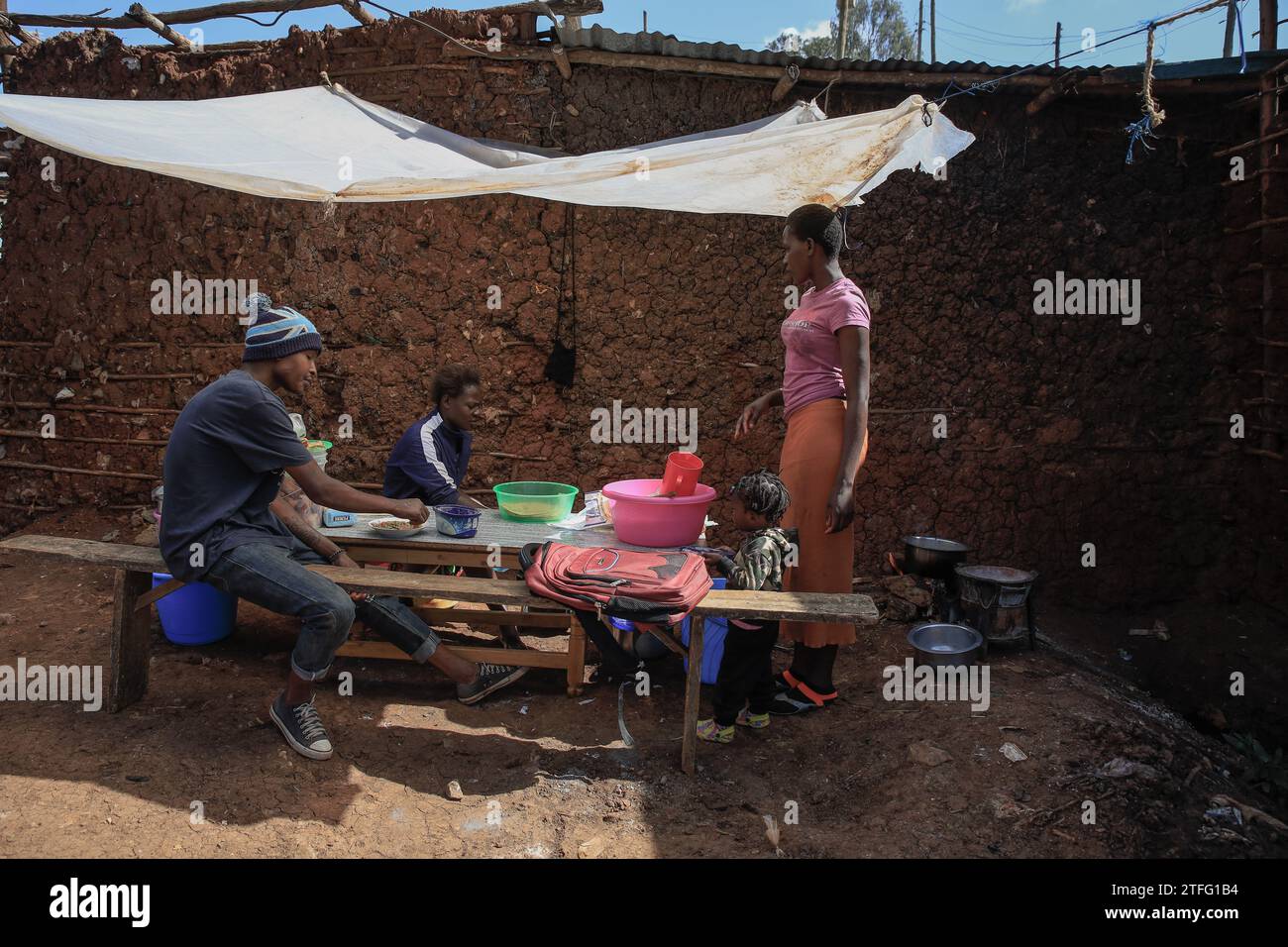 Locals taking their breakfast meal at an open mini restaurant in Kibera ...