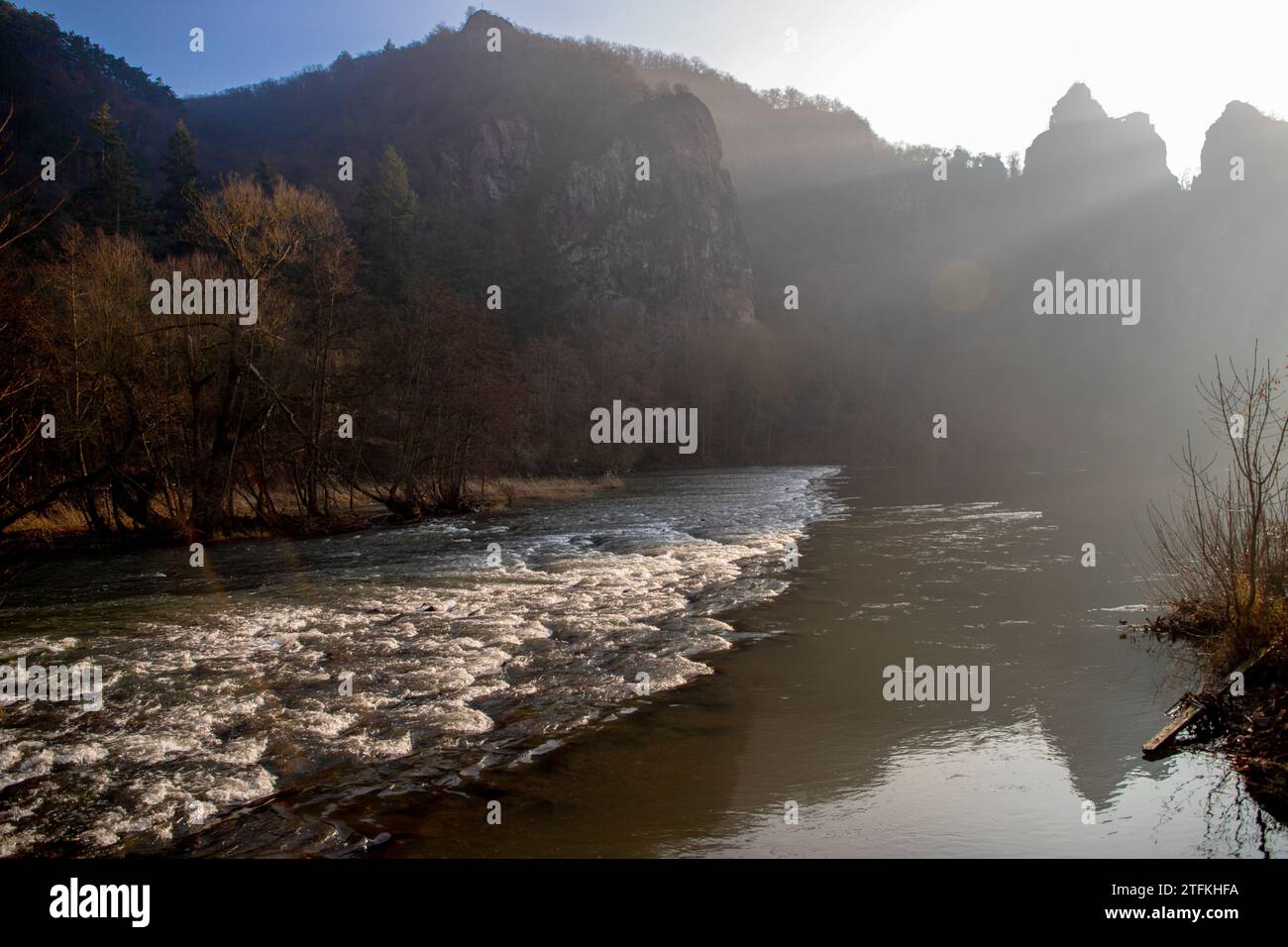 Strong river current with lots of rocks and shrubs in winter Stock ...