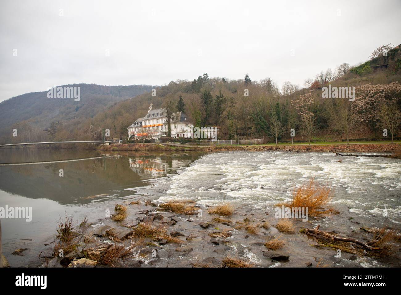 Strong river current with lots of rocks and shrubs in winter Stock ...
