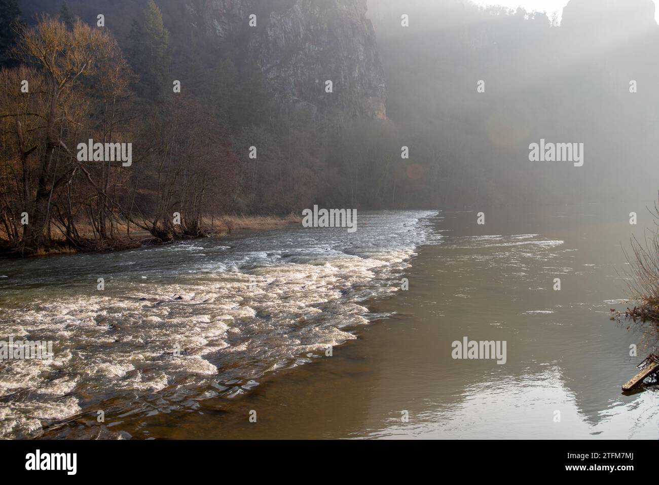 Strong river current with lots of rocks and shrubs in winter Stock ...