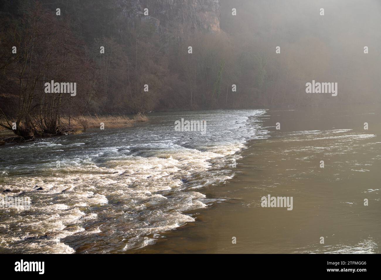 Strong river current with lots of rocks and shrubs in winter Stock ...