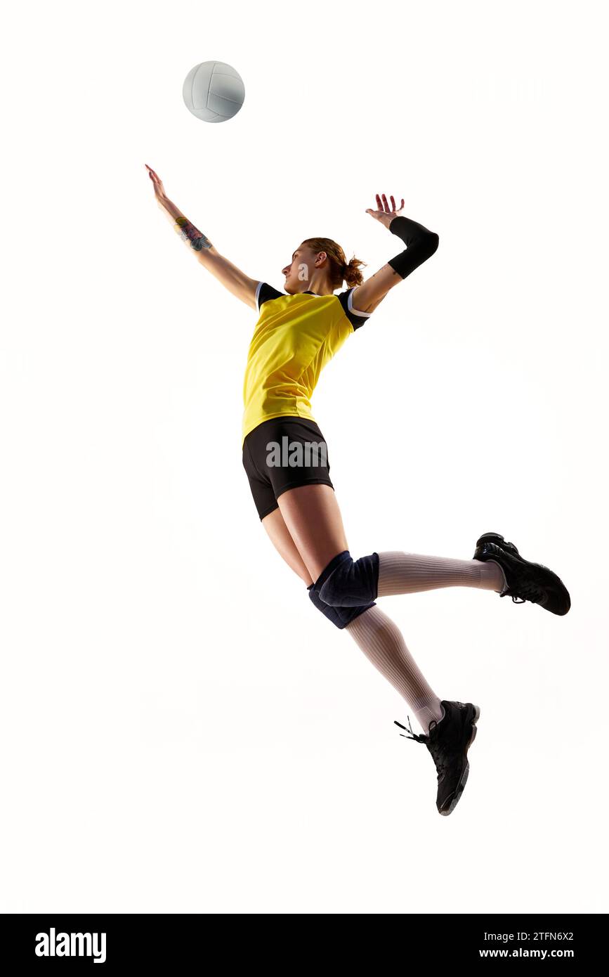 Full-length dynamic image of young woman, volleyball player in motion ...