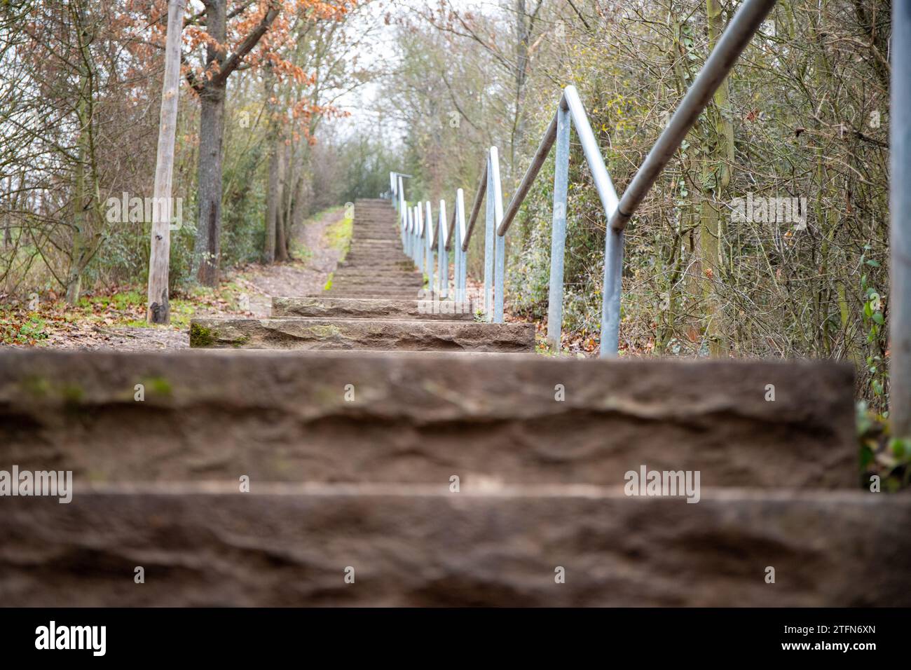 Steep stone steps of a staircase that goes steeply up with metal ...