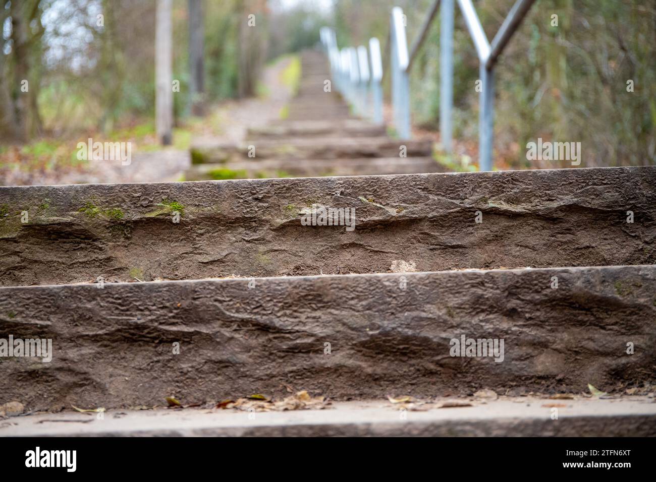 Steep stone steps of a staircase that goes steeply up with metal ...