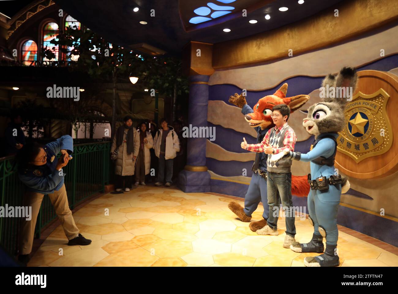 Shanghai. 19th Dec, 2023. A visitor poses for photos with staff members ...