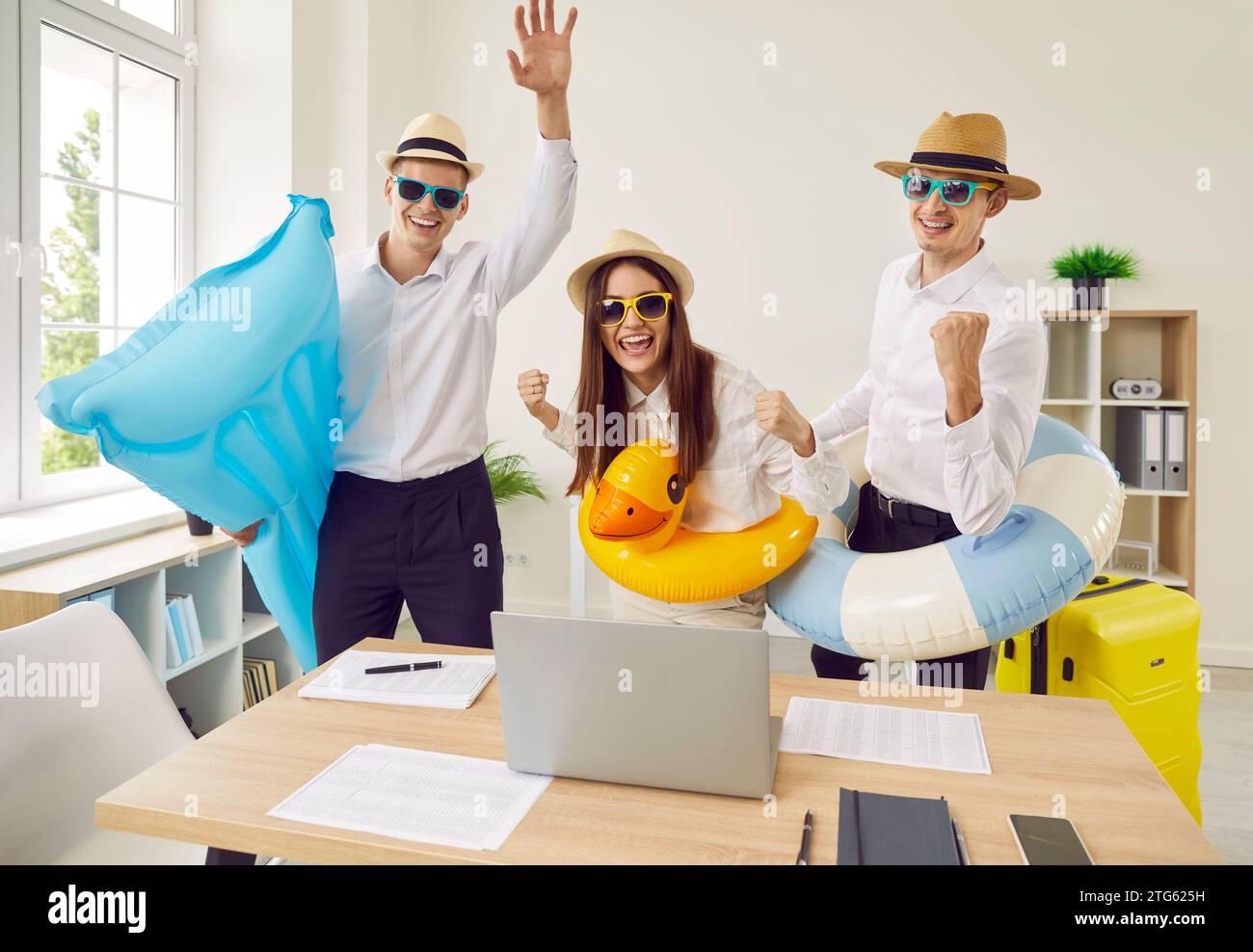 Funny happy company employees standing in office going on summer ...