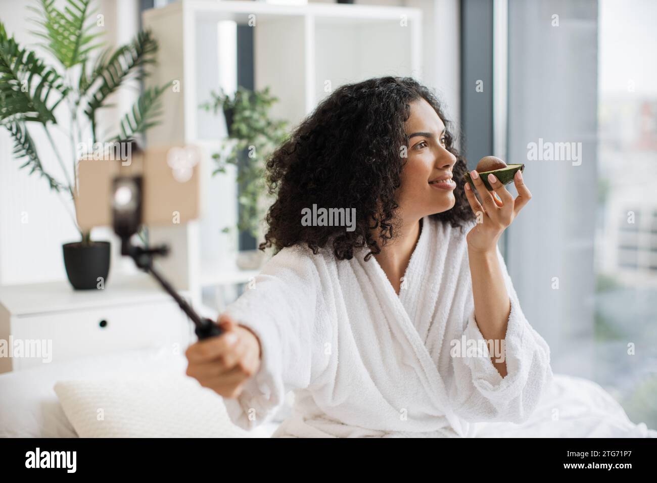 Multiracial female social media influencer enjoying aroma of half of ...