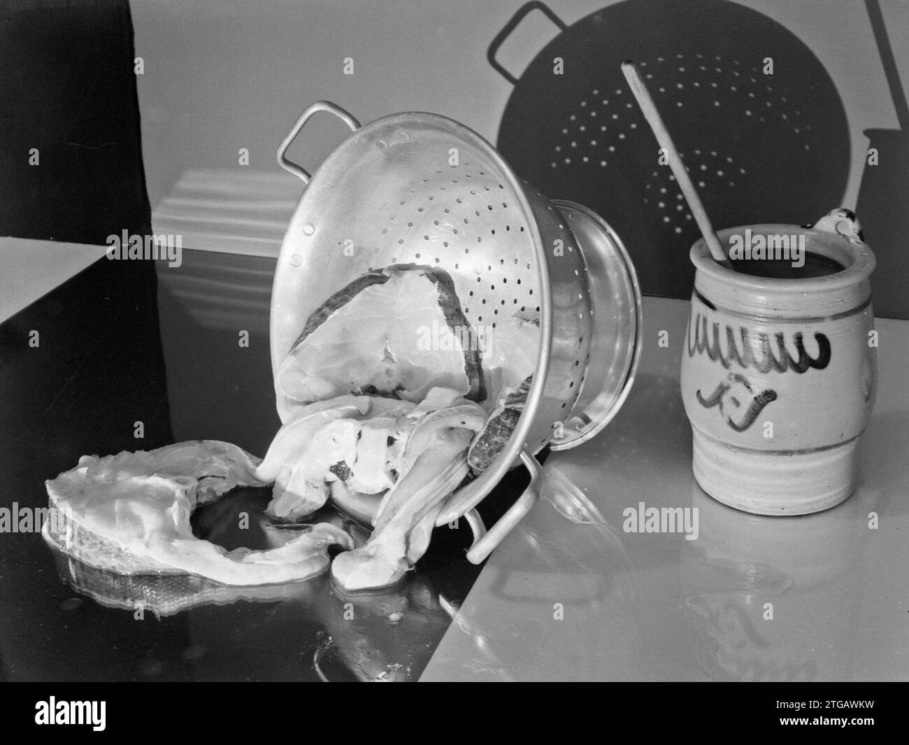 Still life of cod fillets in a colander with a Cologne pot of salt next ...