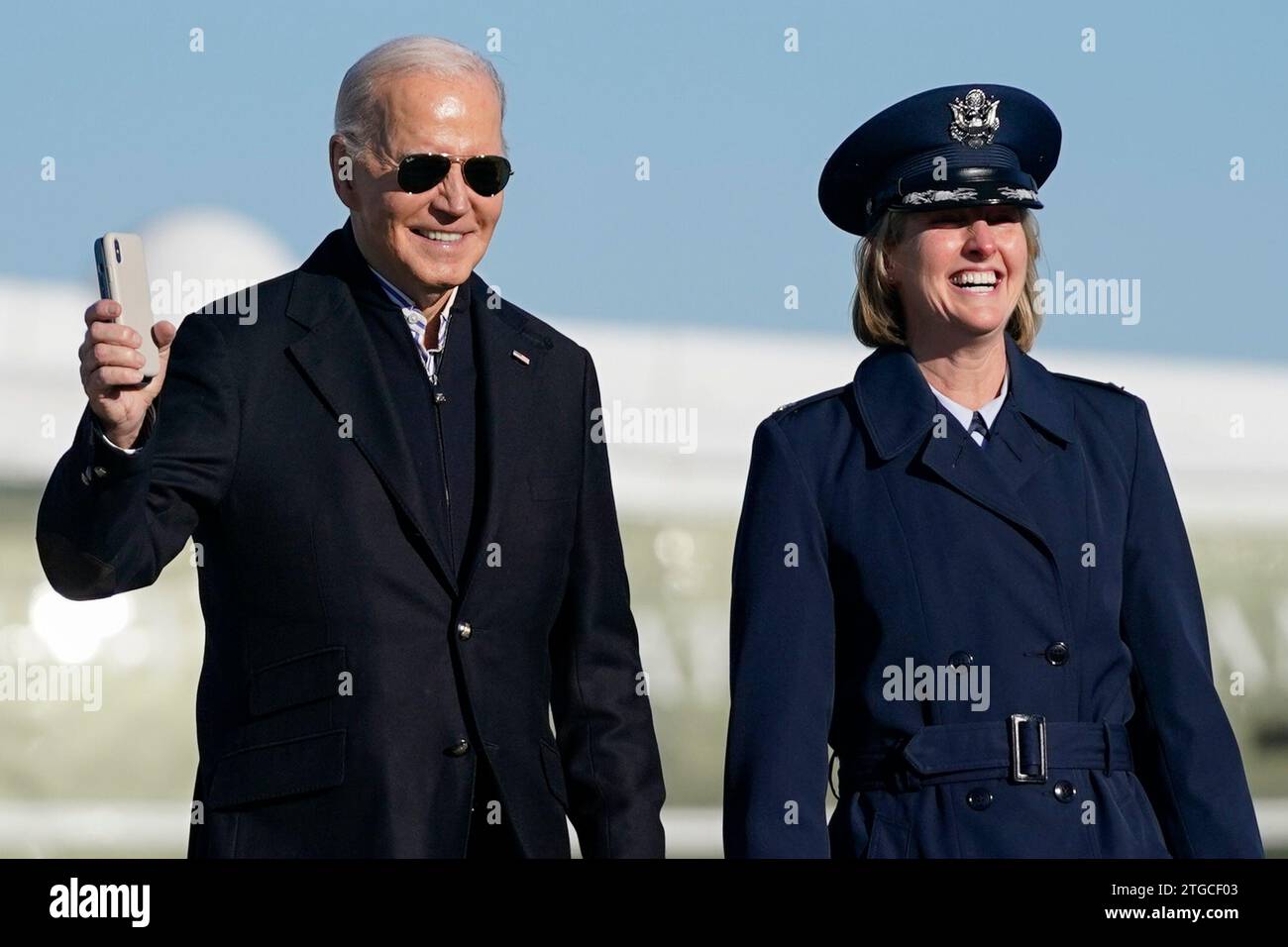 President Joe Biden, escorted by Air Force Col. Angela Ochoa, waves to ...