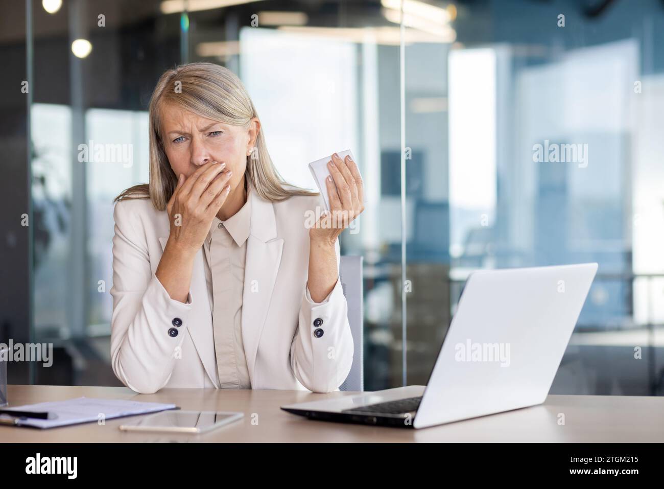 Senior gray-haired woman sick at workplace inside office, businesswoman ...