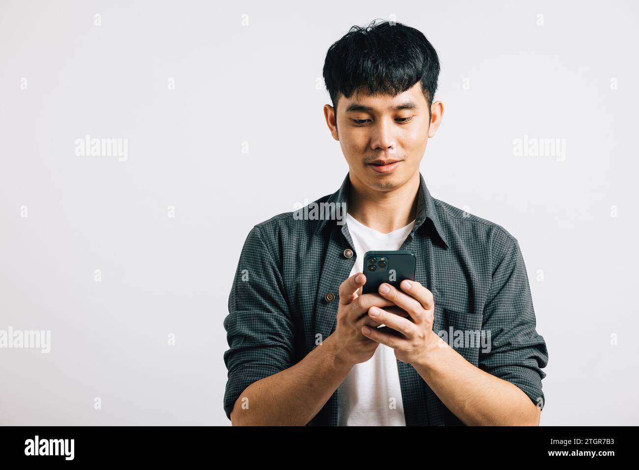 Asian teenager, filled with excitement, types a text message on his ...