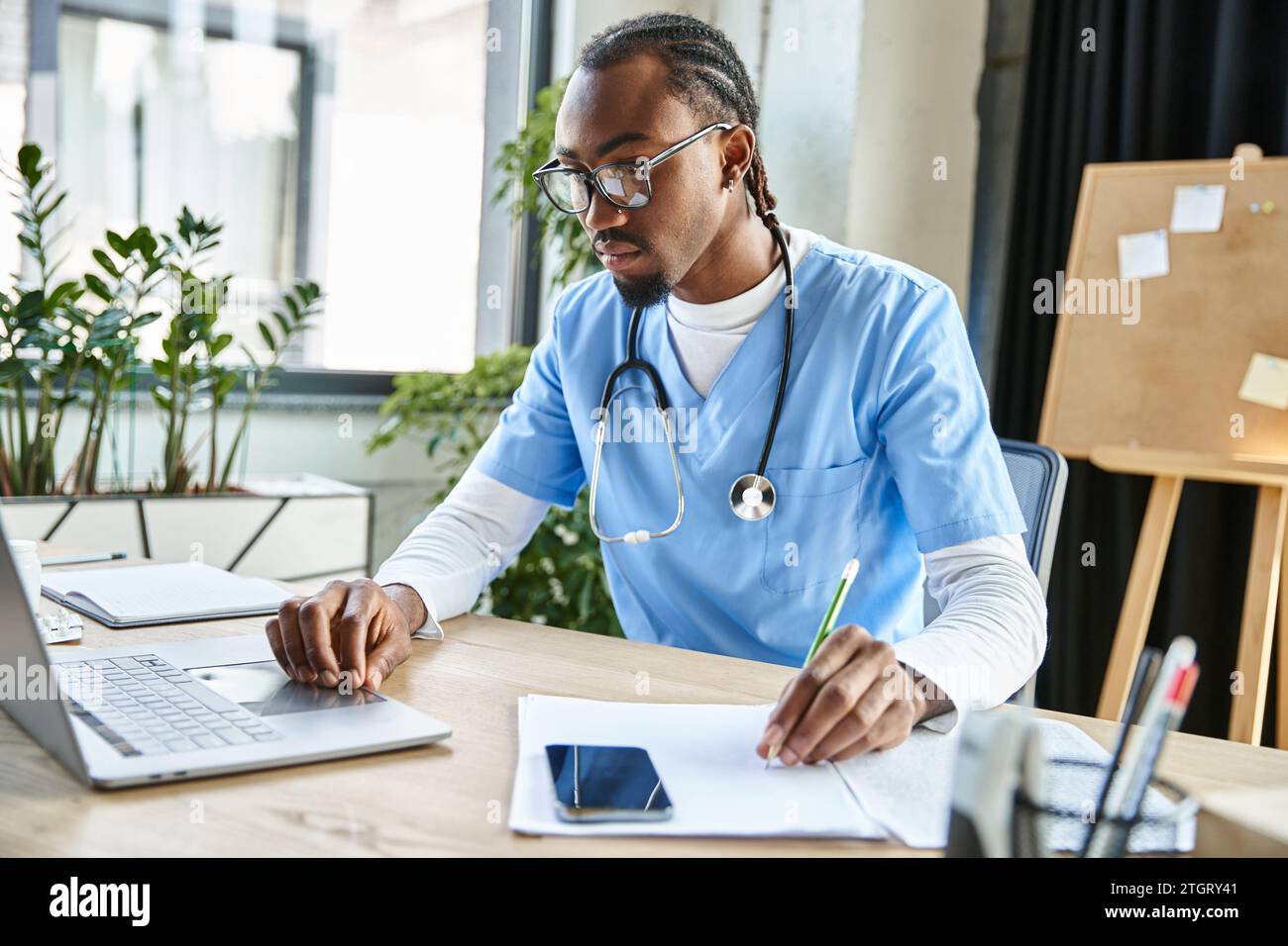 focused good looking african american doctor with glasses taking notes ...