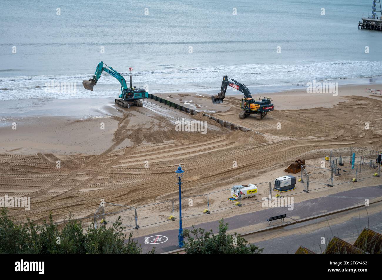 Maintenance diggers Bournemouth beach arranging sand around new ...