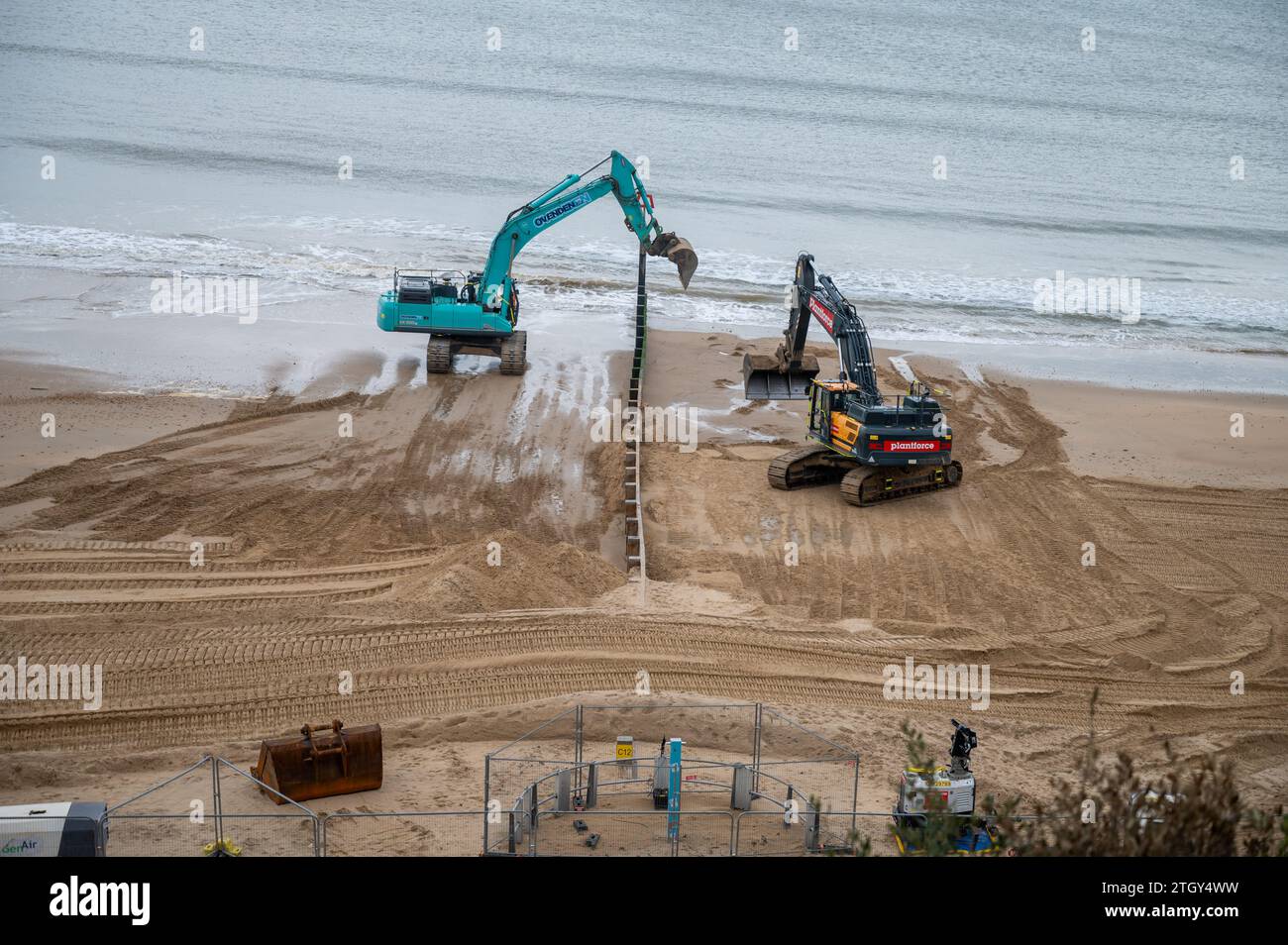 Maintenance diggers Bournemouth beach arranging sand around new ...