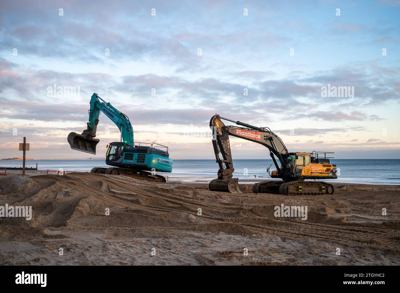 Maintenance diggers Bournemouth beach arranging sand around new ...