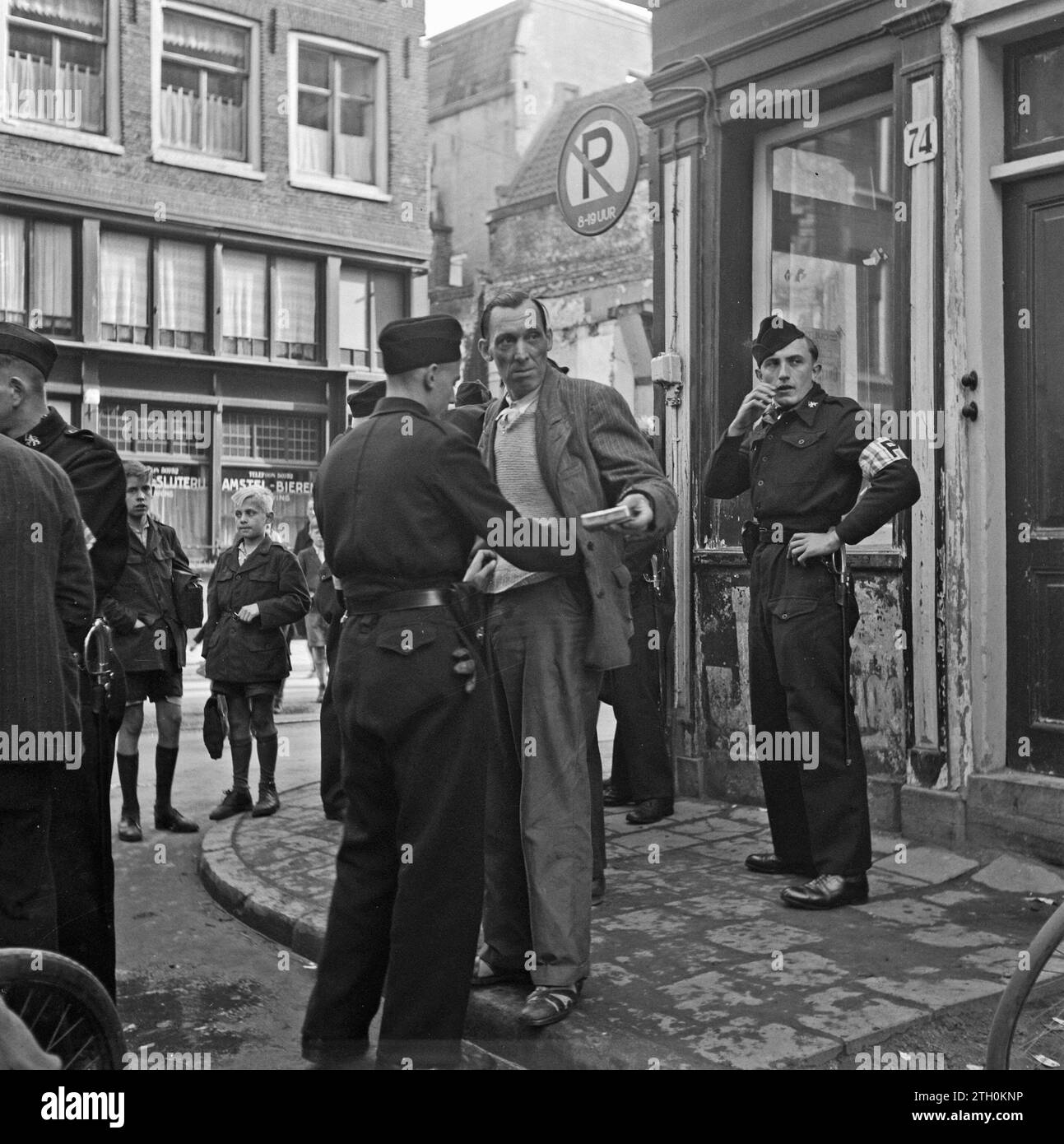 Police conducting a black market raid, searching suspects ca. October ...