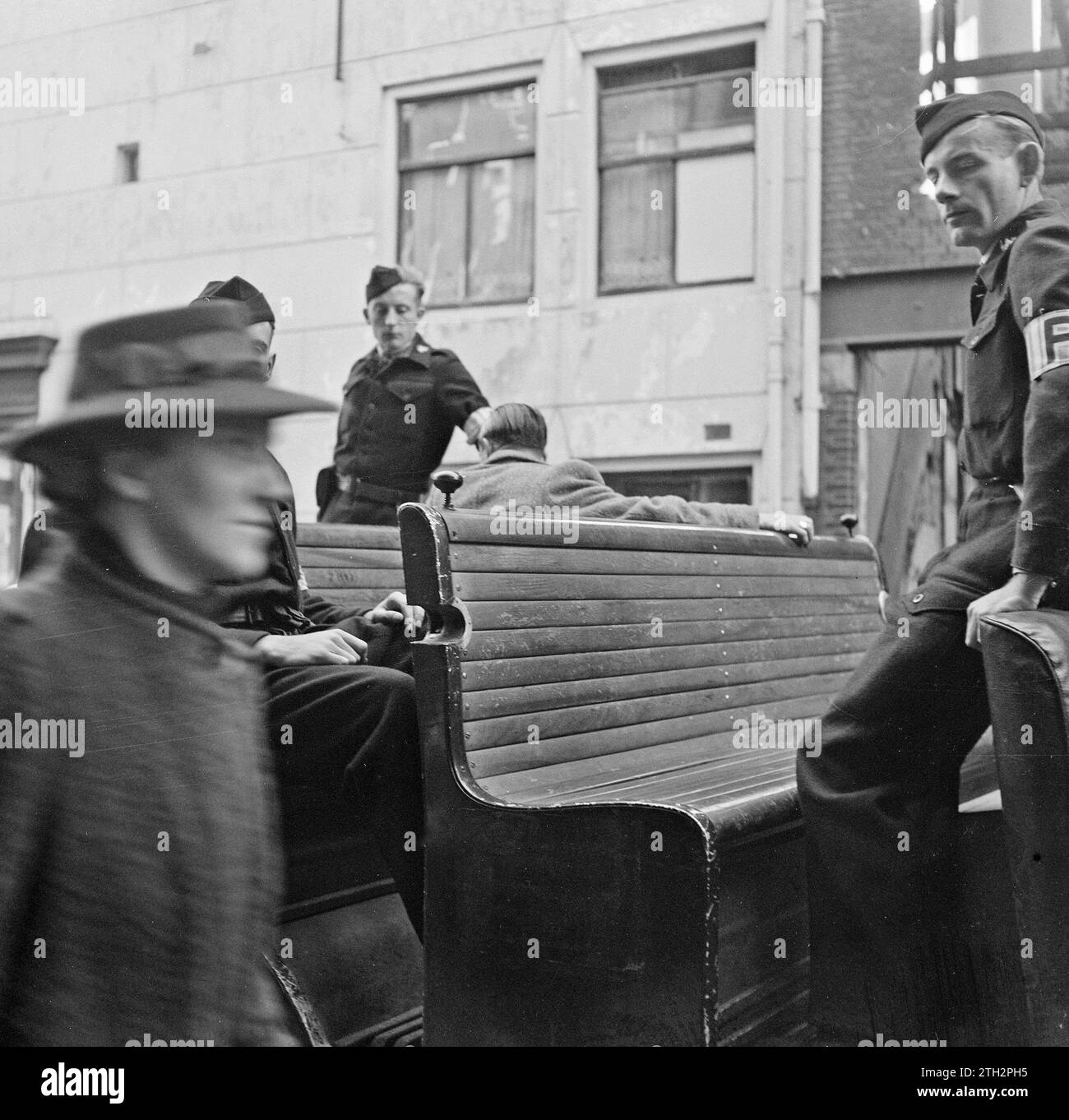 Police conducting a black market raid, searching suspects ca. October ...