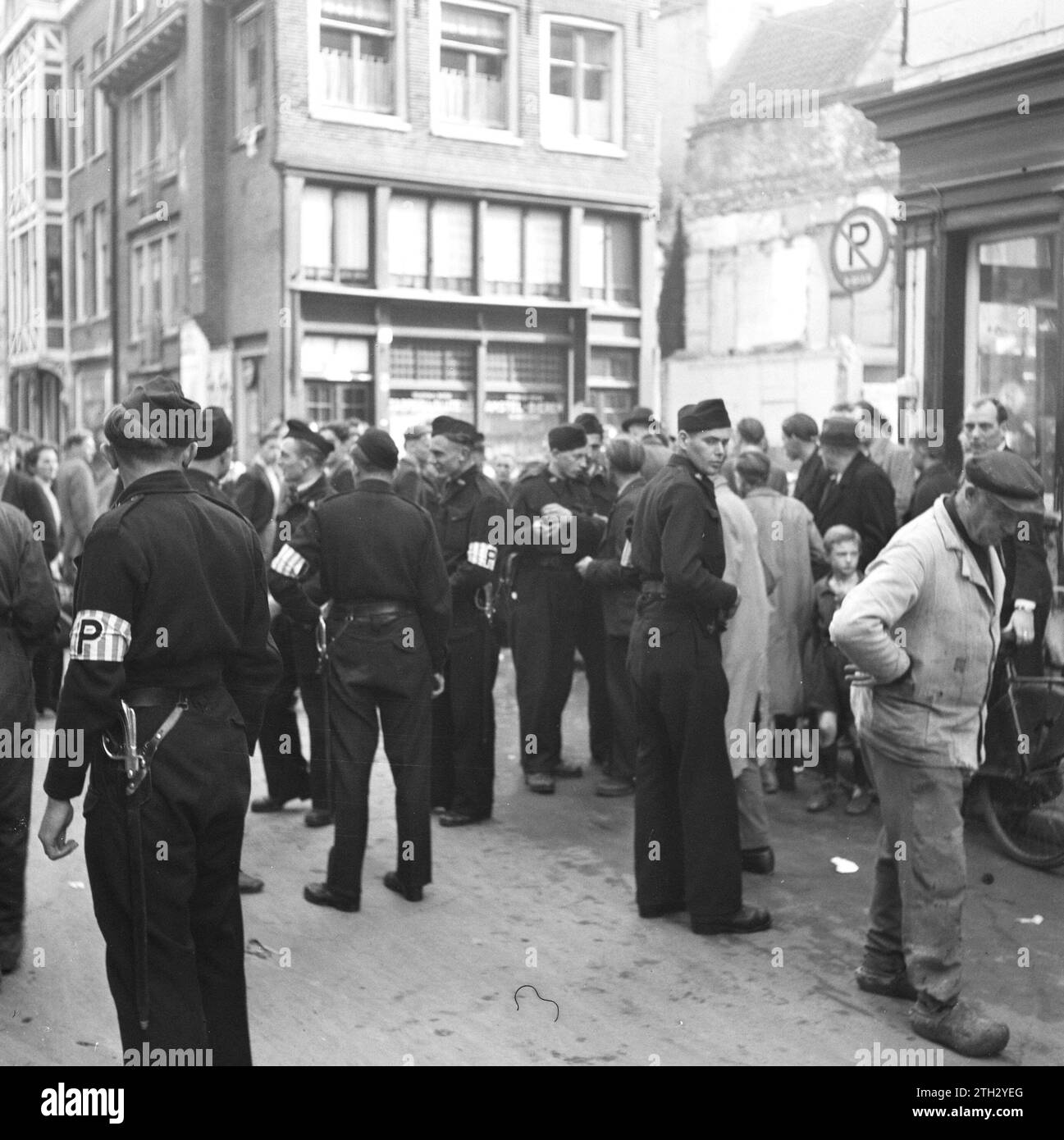 Police conducting a black market raid, searching suspects ca. October ...