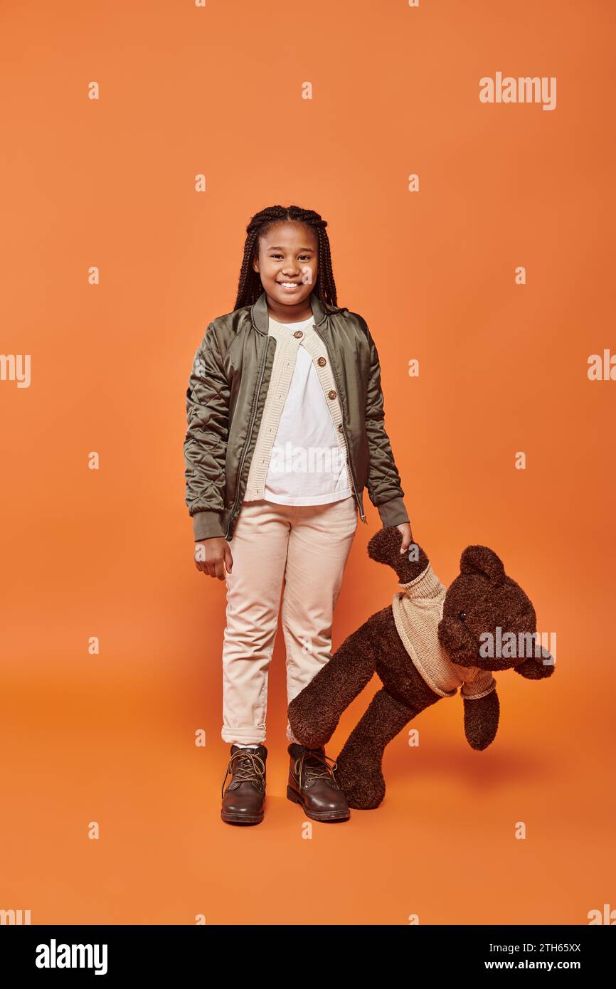 cheerful african american girl with braids posing happily with her ...