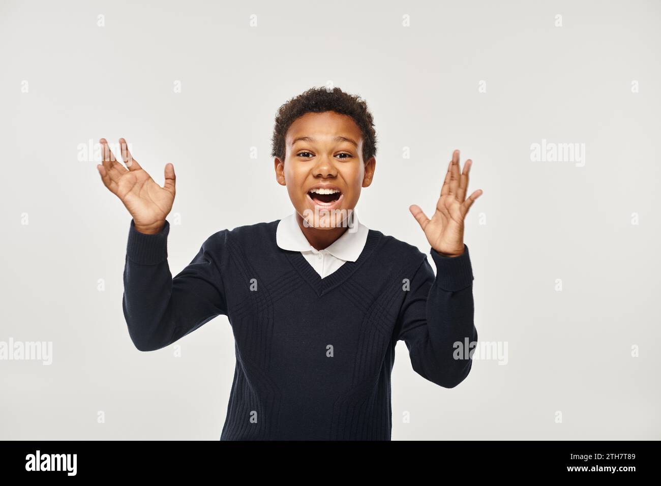 excited african american boy in school uniform rejoicing while looking ...
