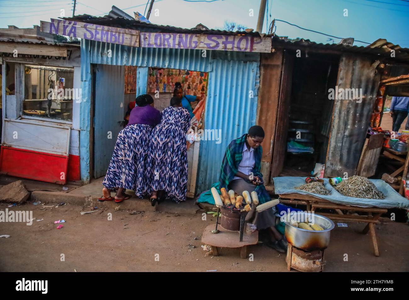 A hawker sells foodstuff by the busy streets in Kibera Slum, Nairobi. A ...