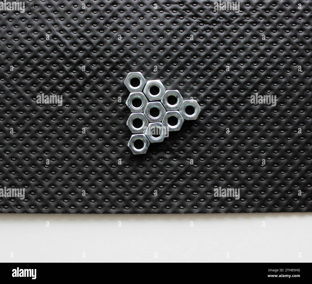Triangle Made By Shiny Hex Nuts On A Black Plastic Sheet With White ...