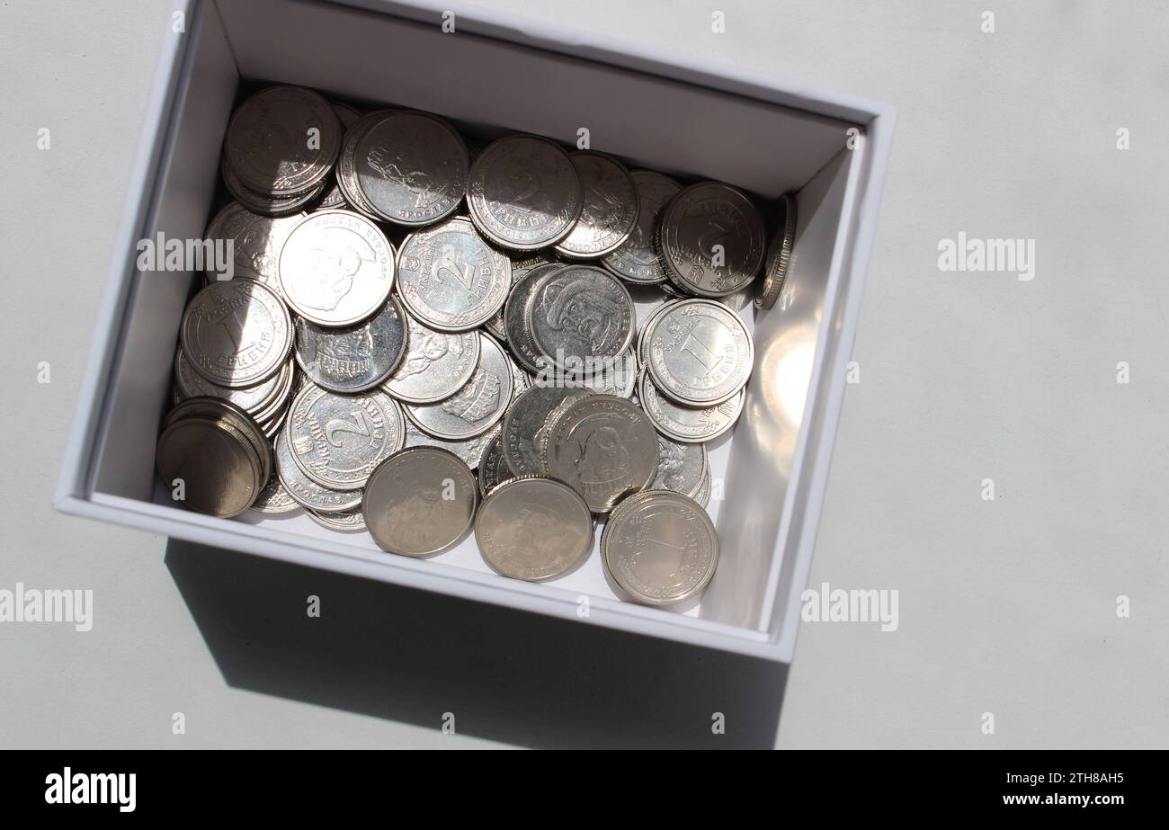 Ukrainian coins denomination 1 and 2 hryvnia in a cardboard box studio ...