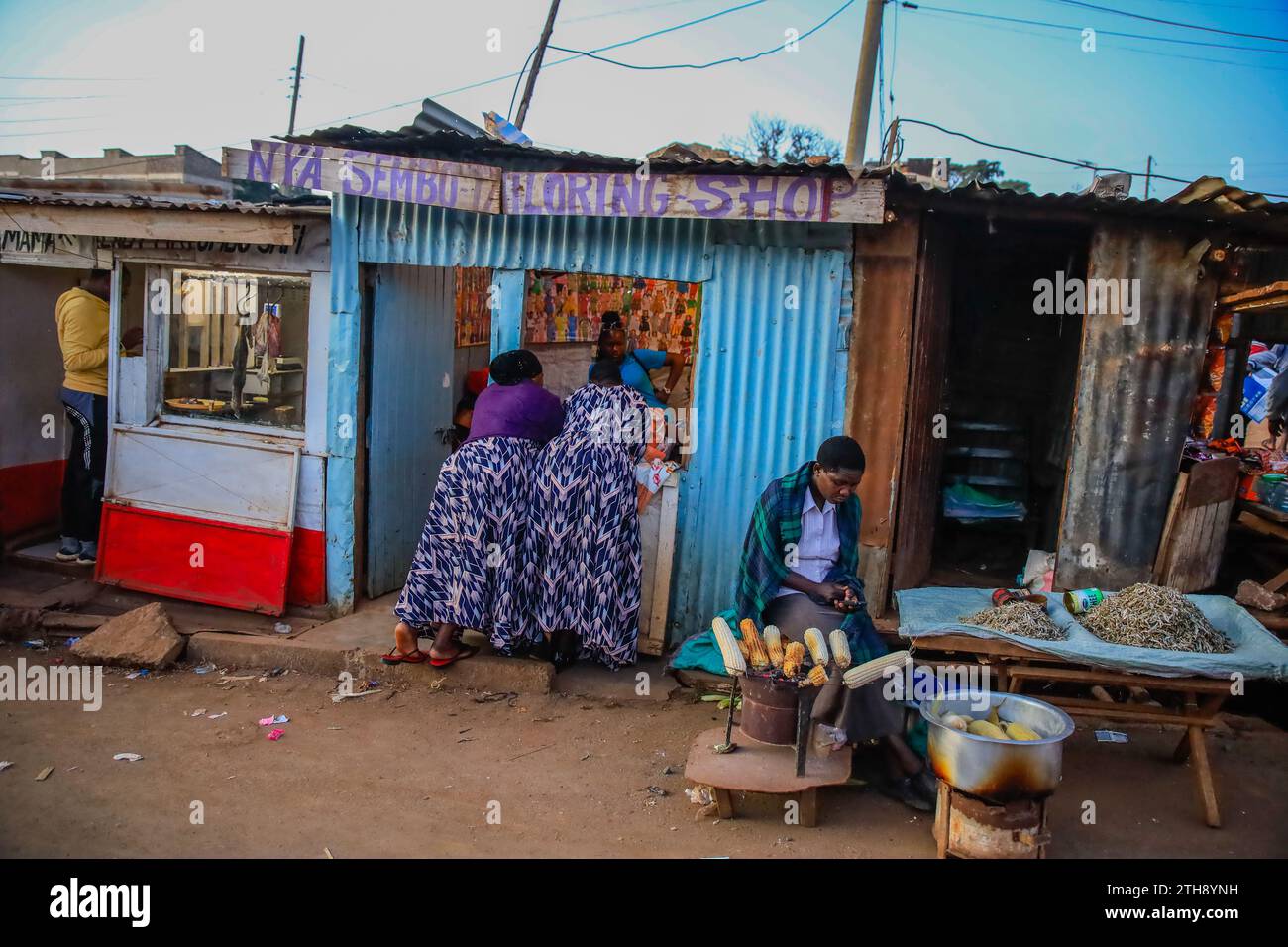 A hawker sells foodstuff by the busy streets in Kibera Slum, Nairobi. A ...