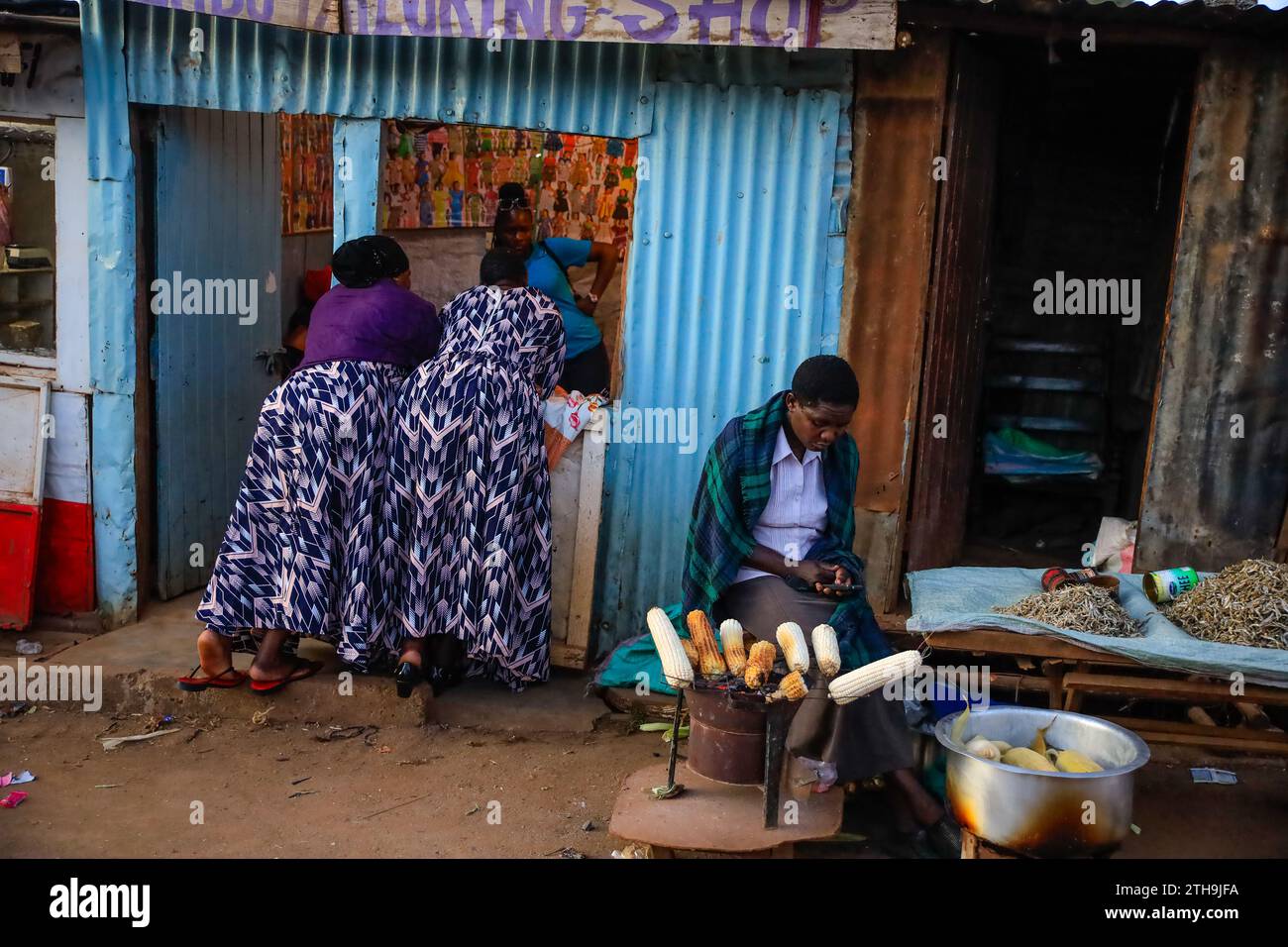 A hawker sells foodstuff by the busy streets in Kibera Slum, Nairobi. A ...
