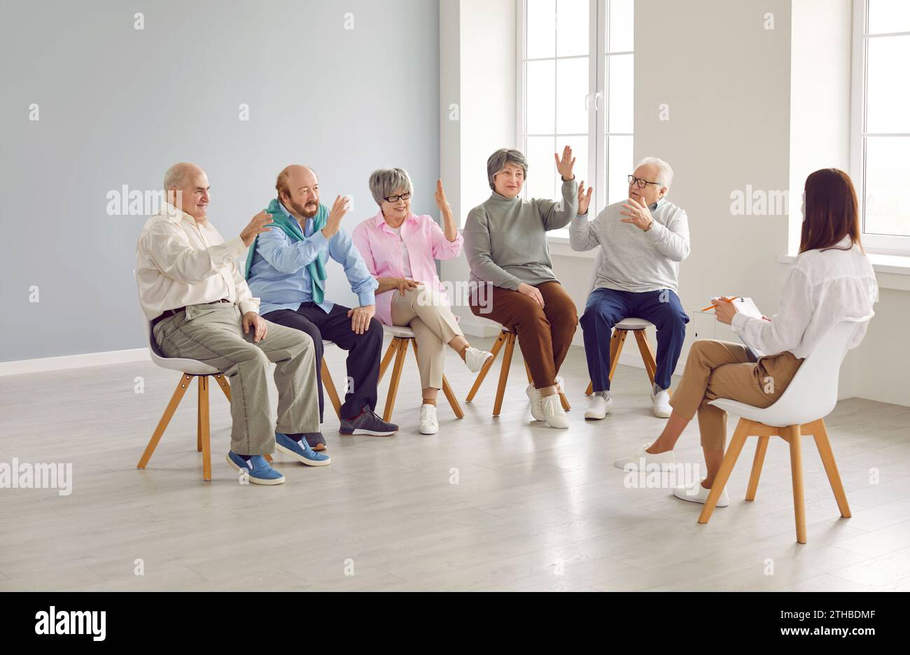 Group of senior people raising hands to pose questions to teacher ...