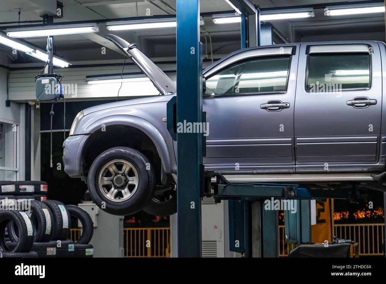 Pickup truck lifted into the air using a mechanical bridge jack in a ...