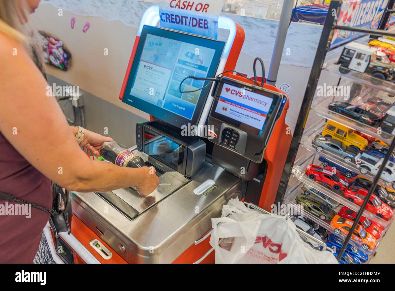 Close-up view of a woman scanning items at the self-service checkout in ...