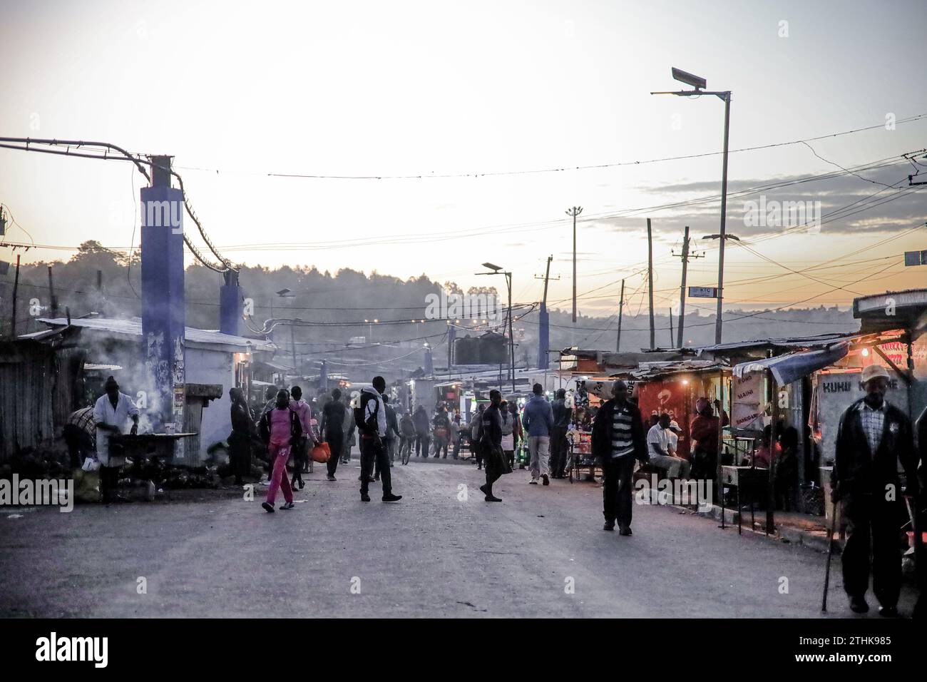 Residents walk past the busy business streets in Kibera Slum, Nairobi ...