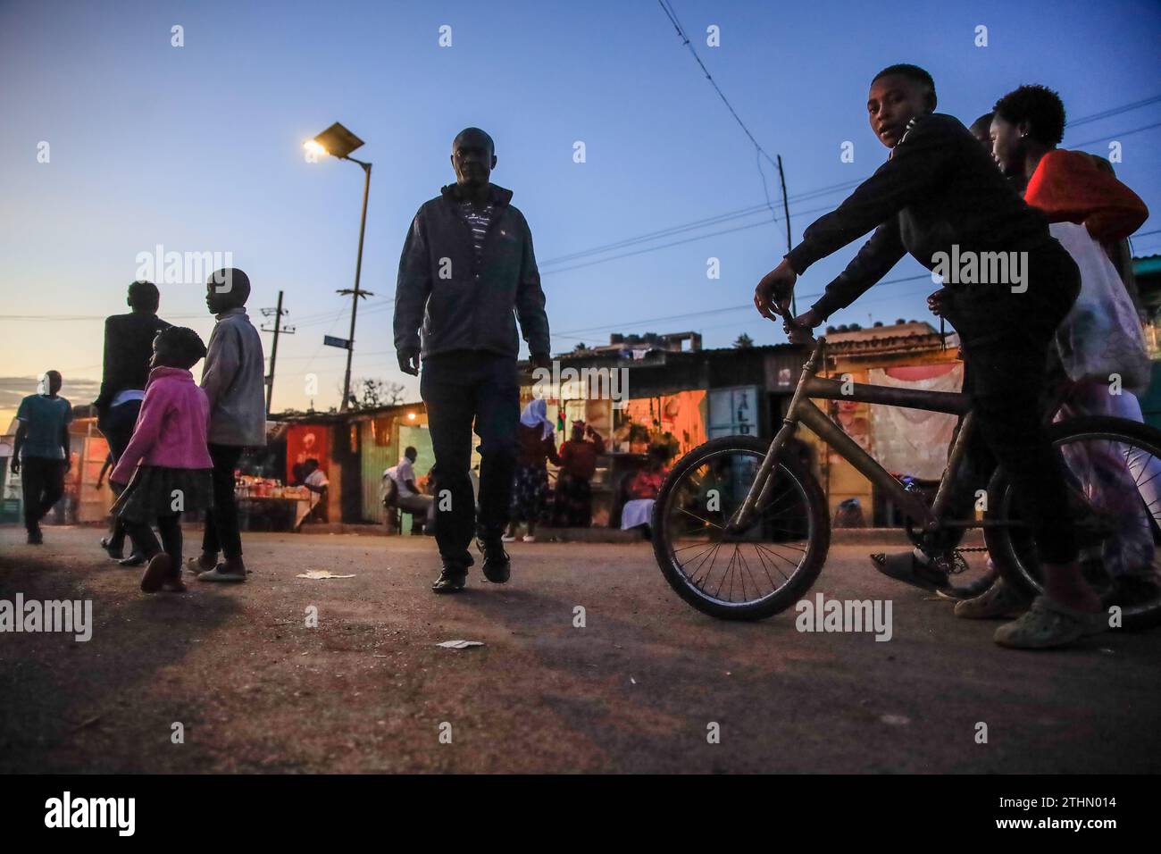 Residents walk past the busy business streets in Kibera Slum, Nairobi ...