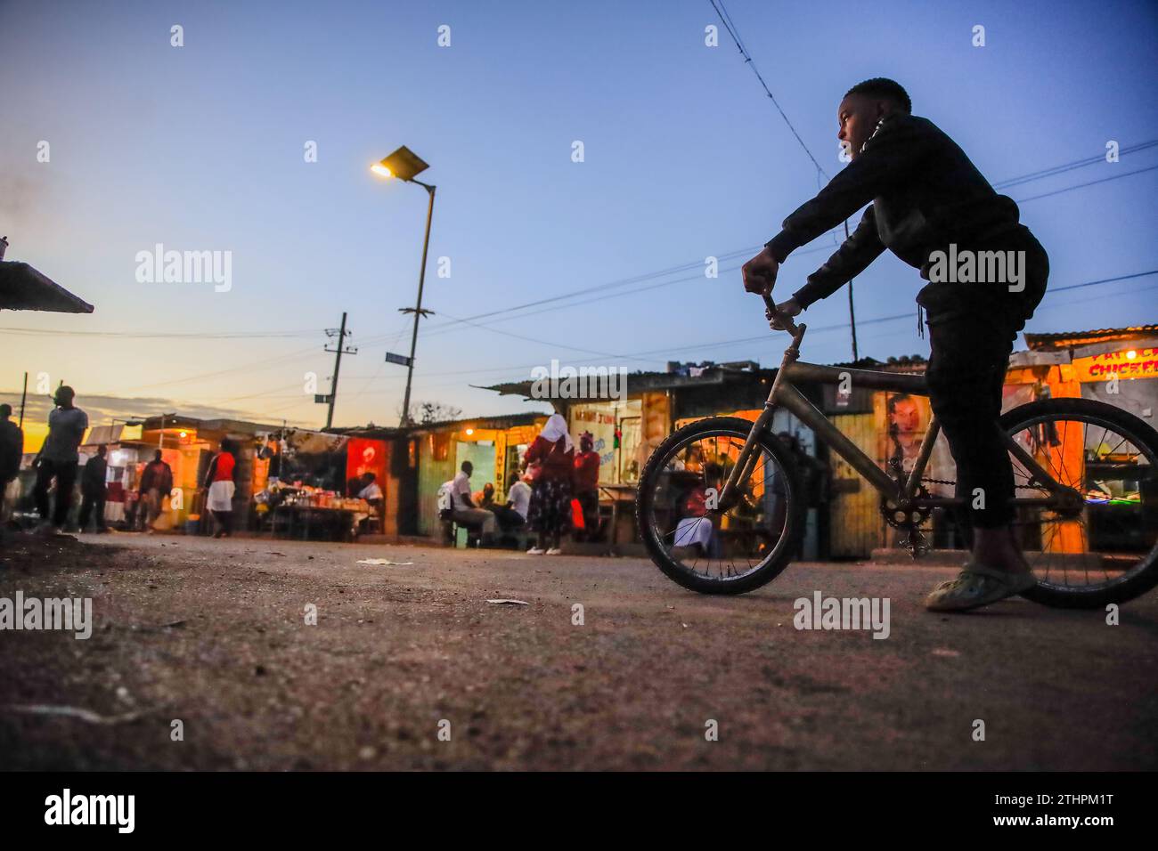 Residents walk past the busy business streets in Kibera Slum, Nairobi ...