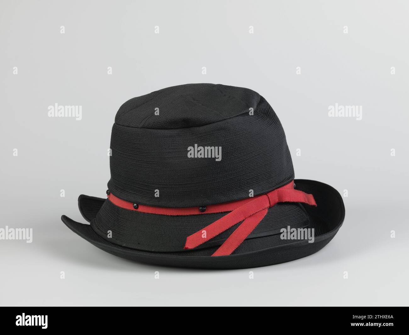Hat of black stitched satin decorated with a red rip ribbon and black ...