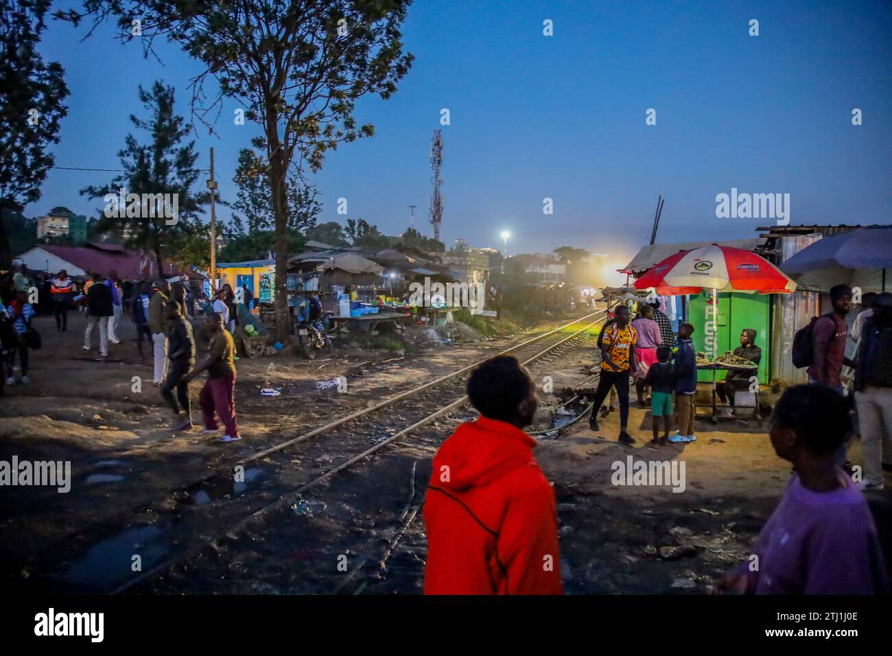 Residents walk past a train line running through the center of Kibera ...