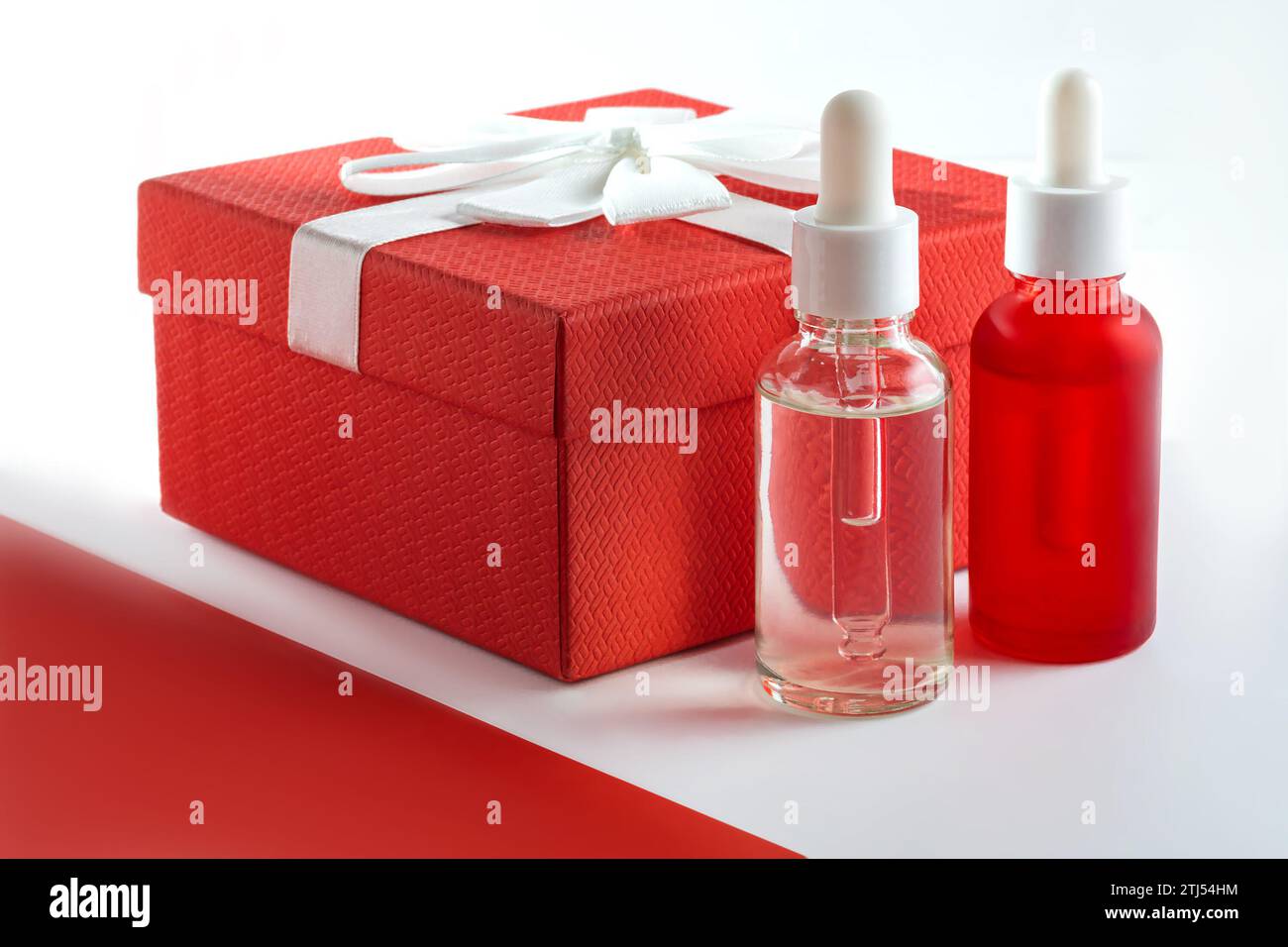 Serum glass bottles with pipette on the white background and red gift ...