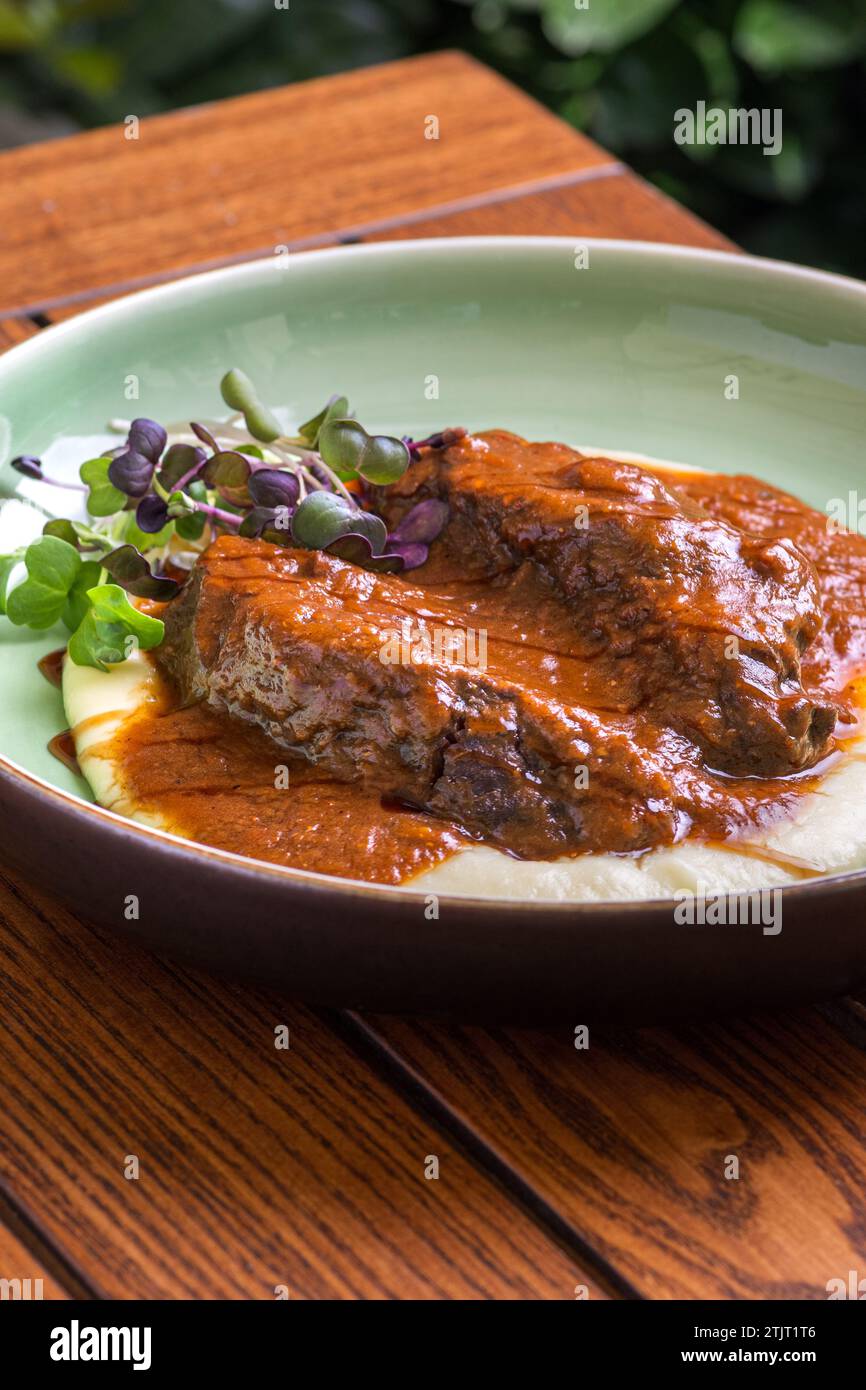 Traditional German braised pork cheeks in brown red wine sauce. Food on ...