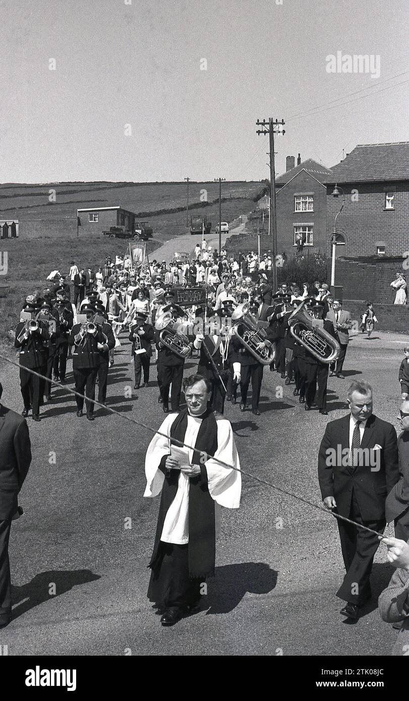 1960s, historical, a priest leading a procession of people and marching ...