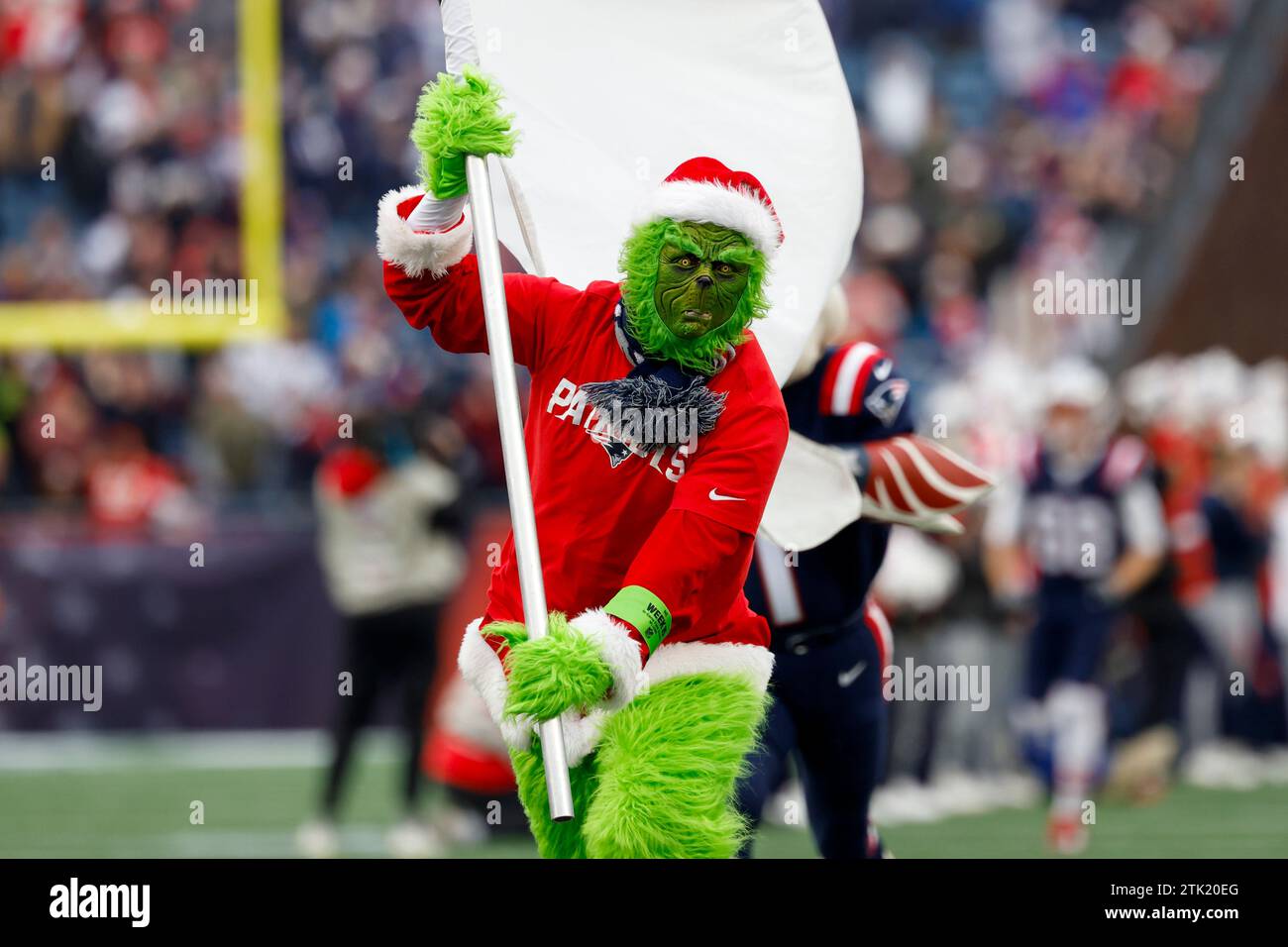 A person dressed as the Grinch runs with a flag during player ...