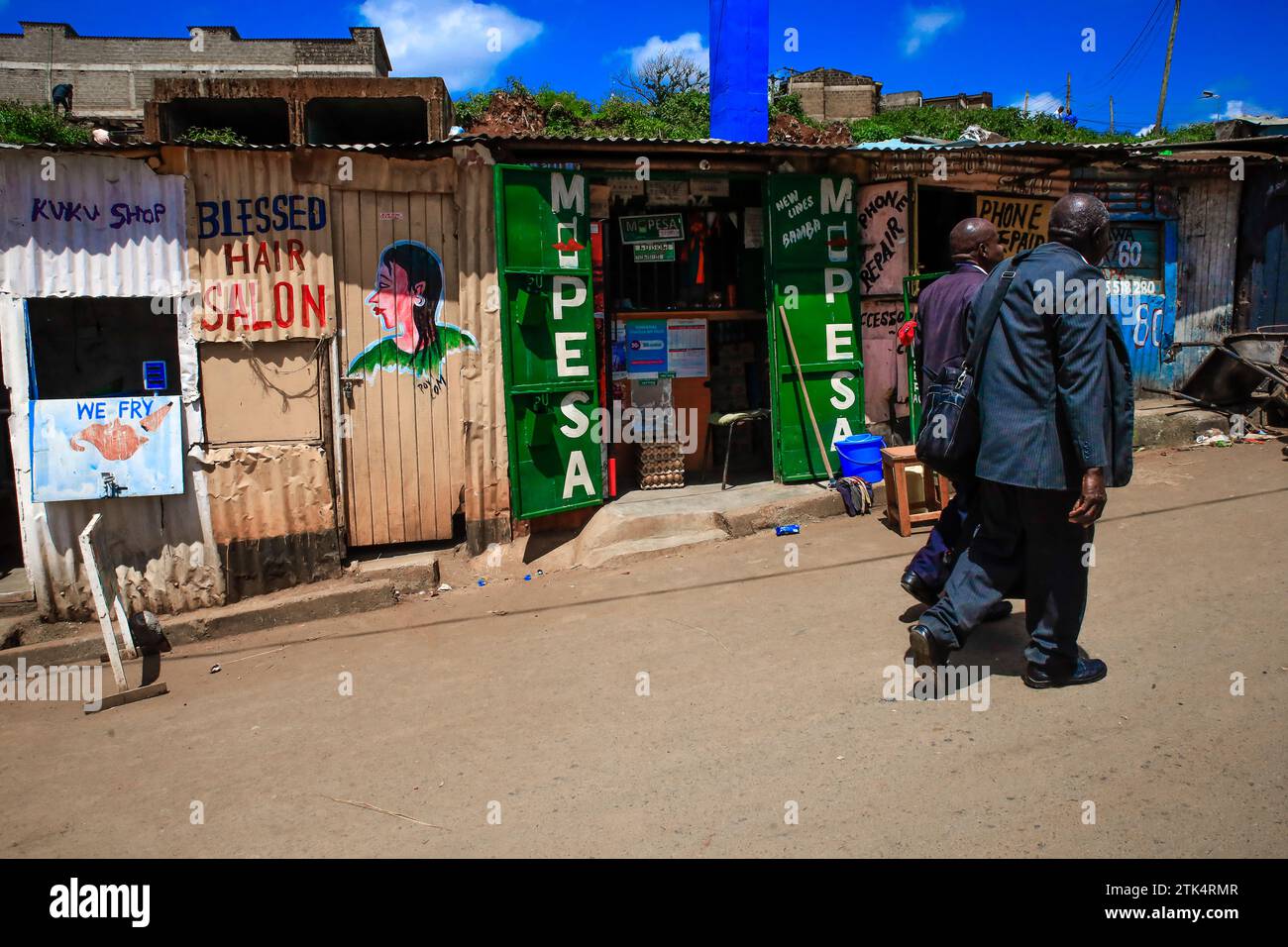 Residents walk past the busy streets in Kibera Slum, Nairobi. A view ...