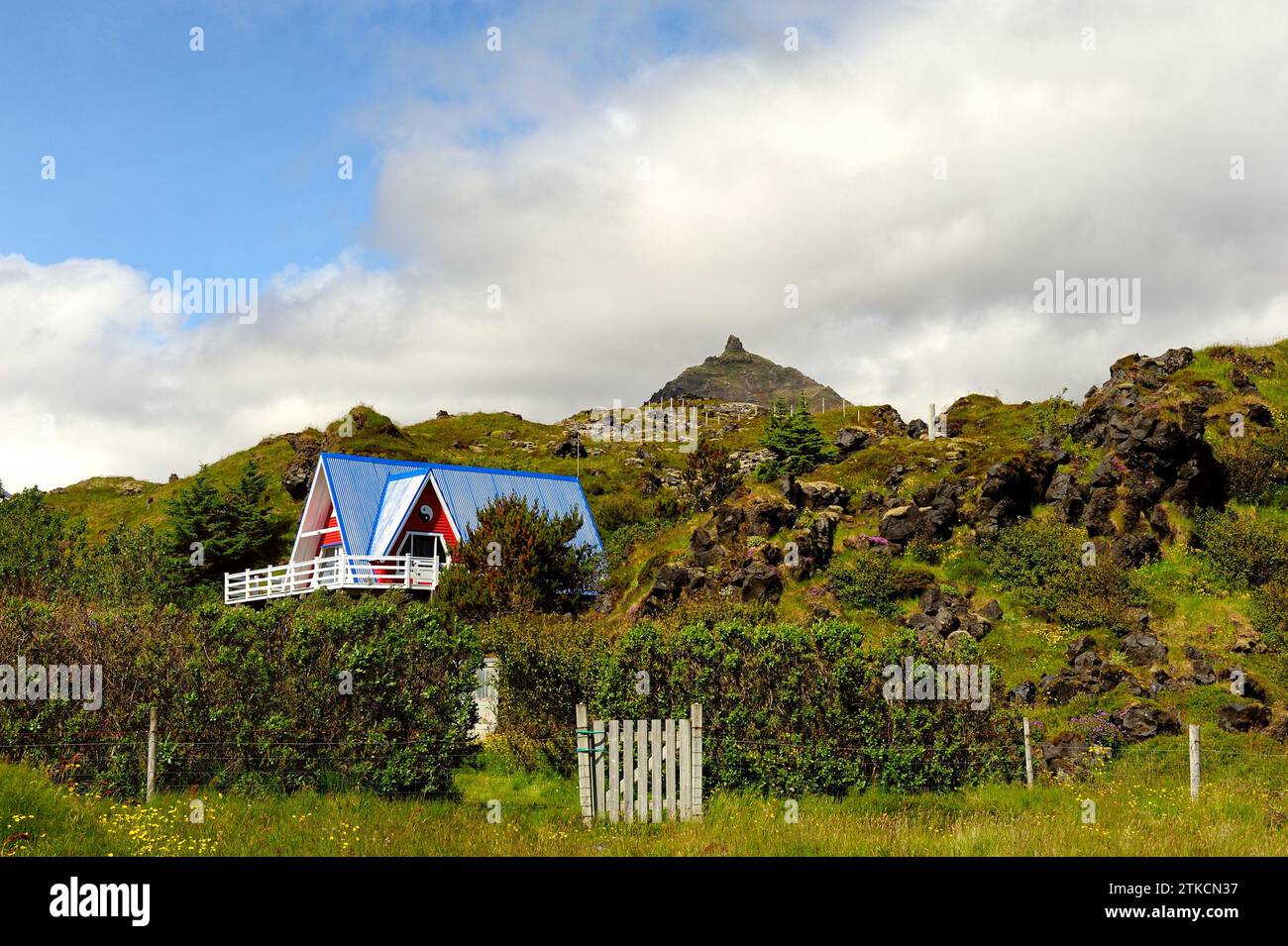 Blue roofed farm building below the volcanic mountain Stock Photo - Alamy