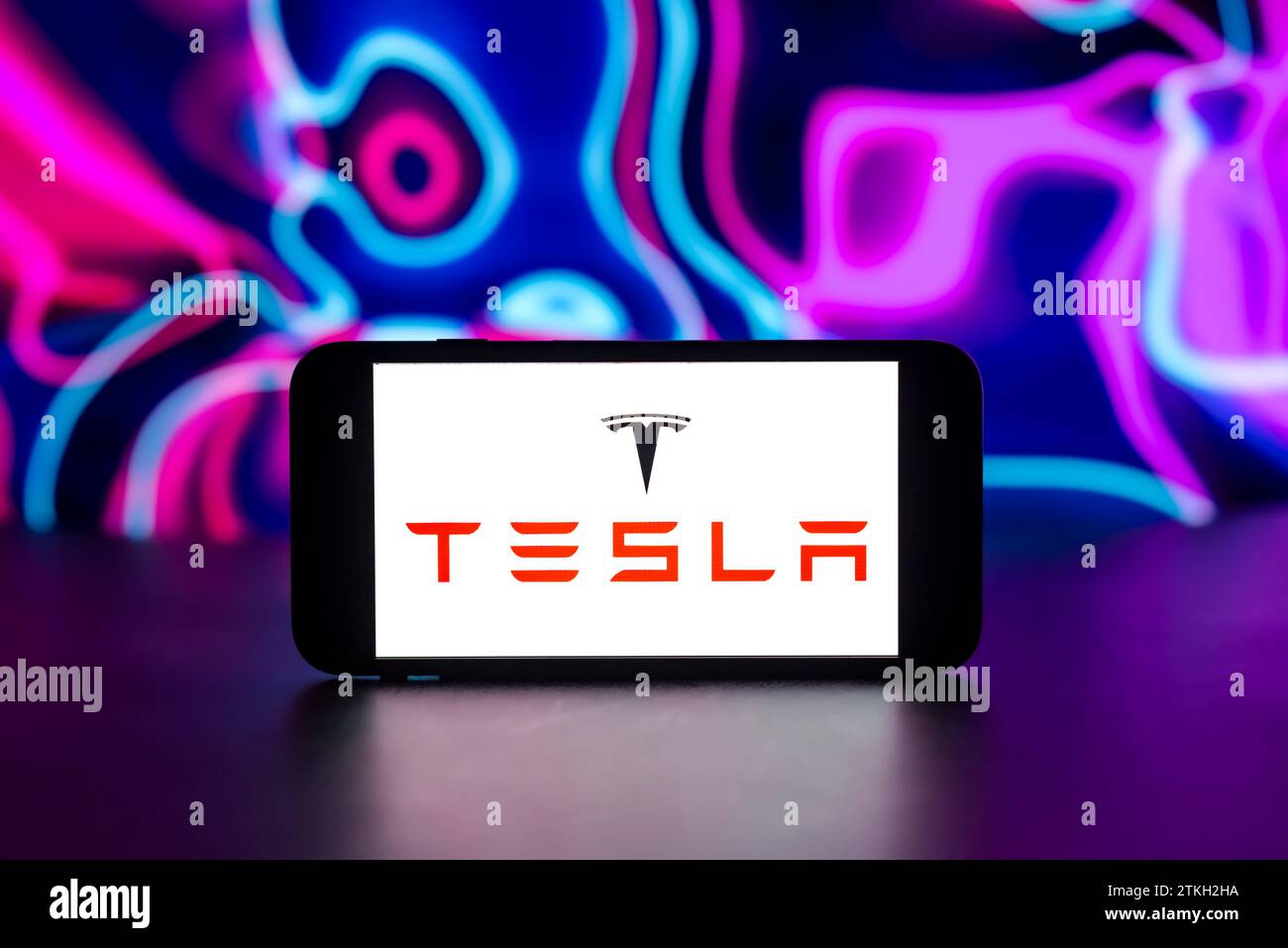 In this photo illustration, the Tesla logo is seen displayed on a ...