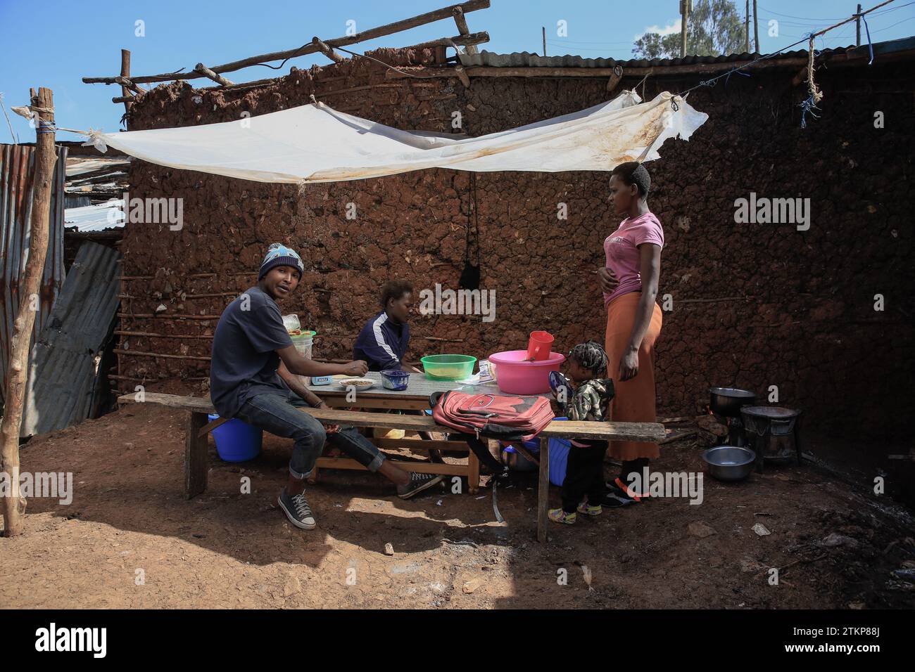 Locals taking their breakfast meal at an open mini restaurant in Kibera ...