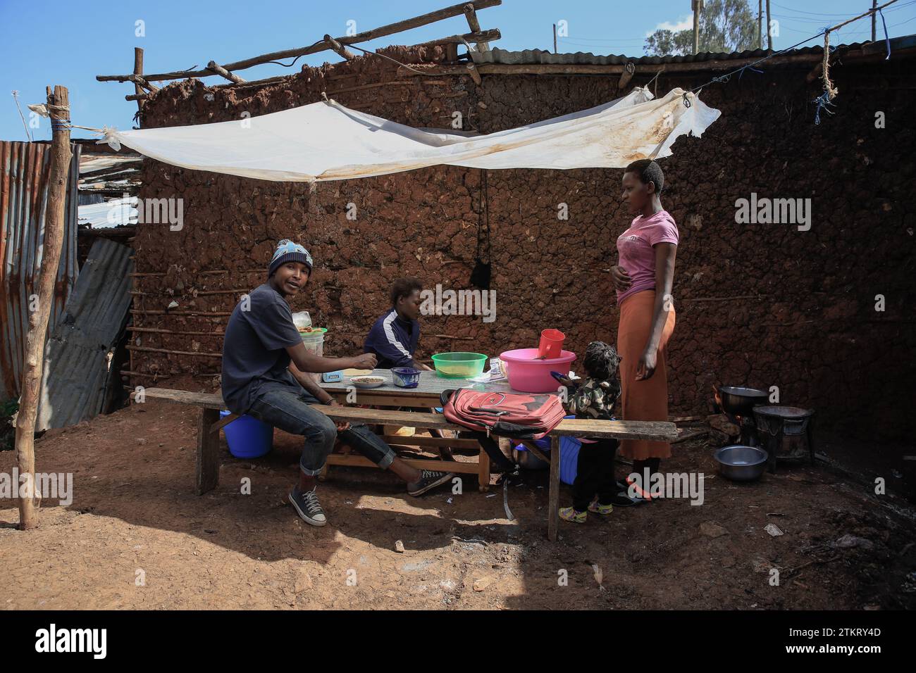 Locals taking their breakfast meal at an open mini restaurant in Kibera ...