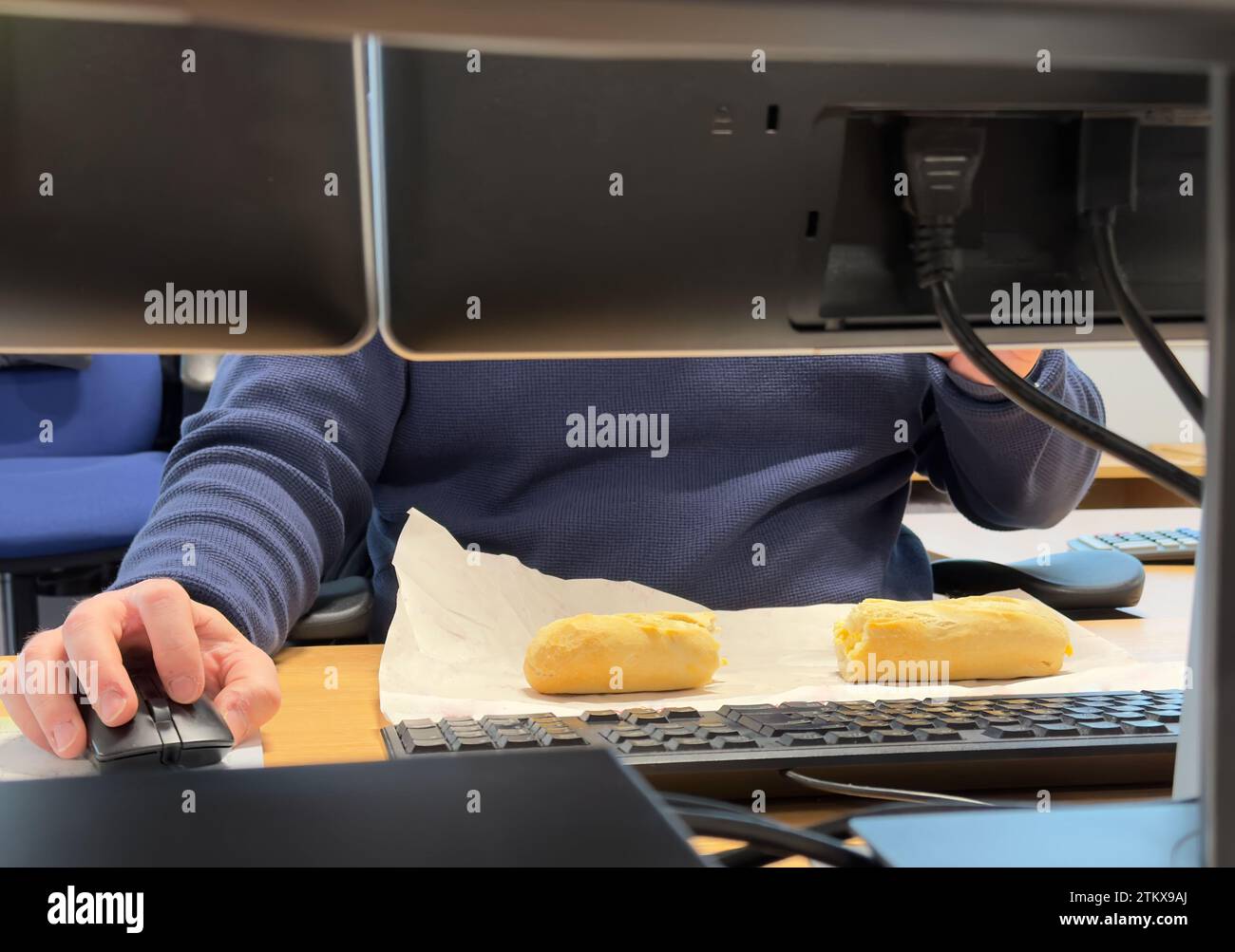 Worker eating at desk in office and not being productive Stock Photo ...