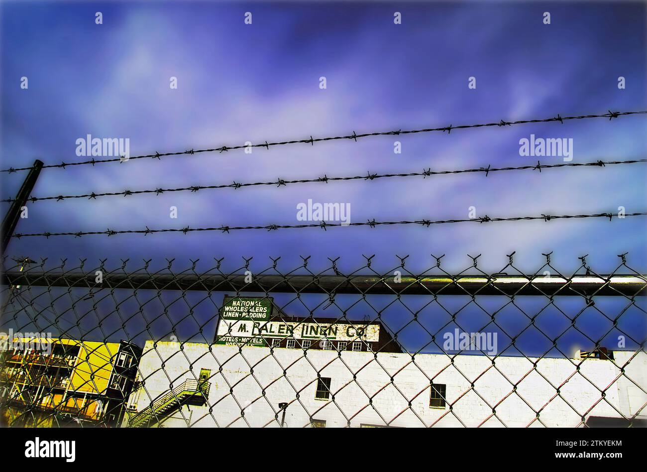 Barb wire and chain link sense enclosing some industrial buildings in ...